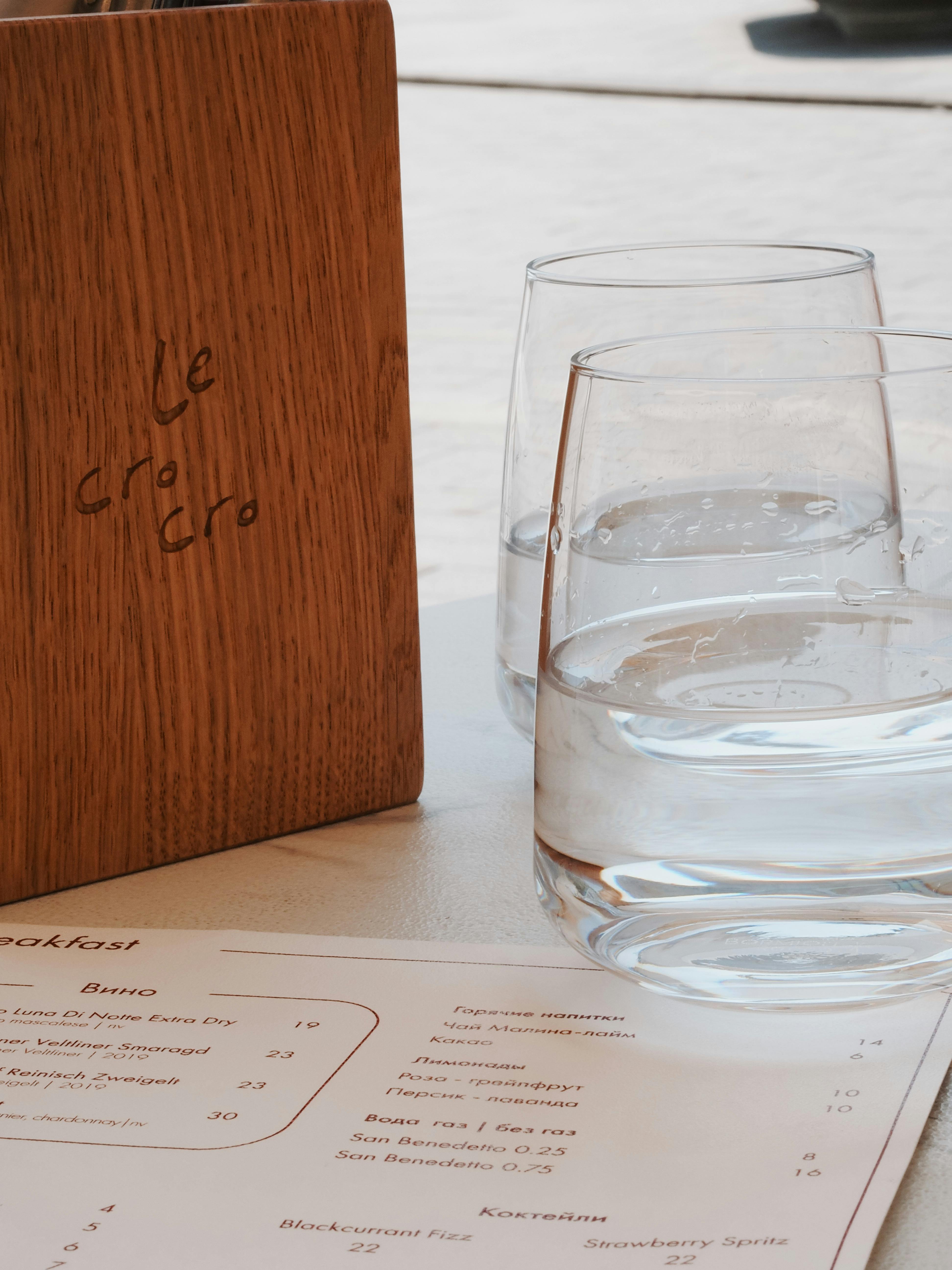 Elegant Cafe Table Setting with Menu and Water · Free Stock Photo