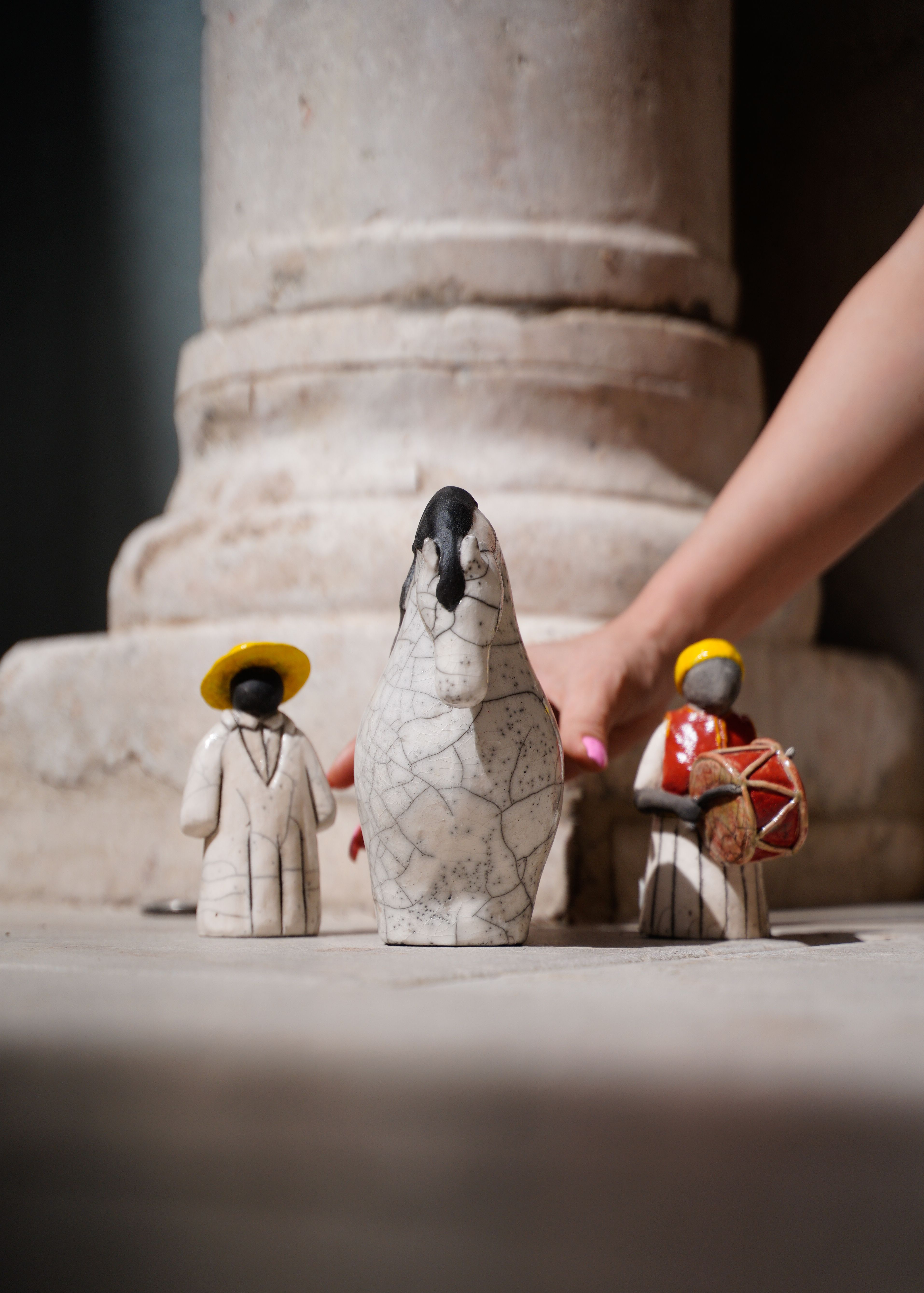 Stone Figurines with Person Adjusting Display · Free Stock Photo