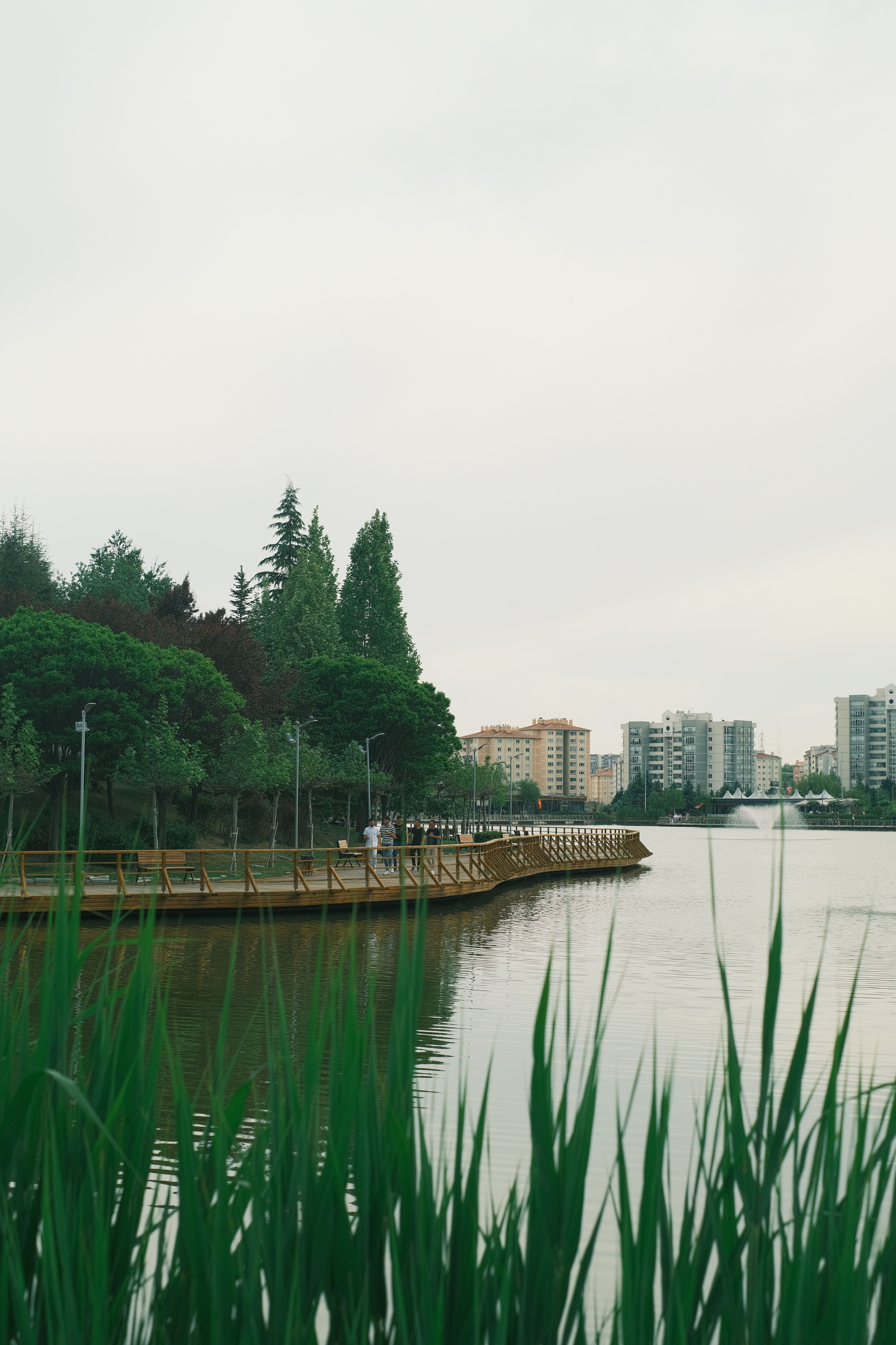 Scenic Urban Lake with Boardwalk and Buildings · Free Stock Photo