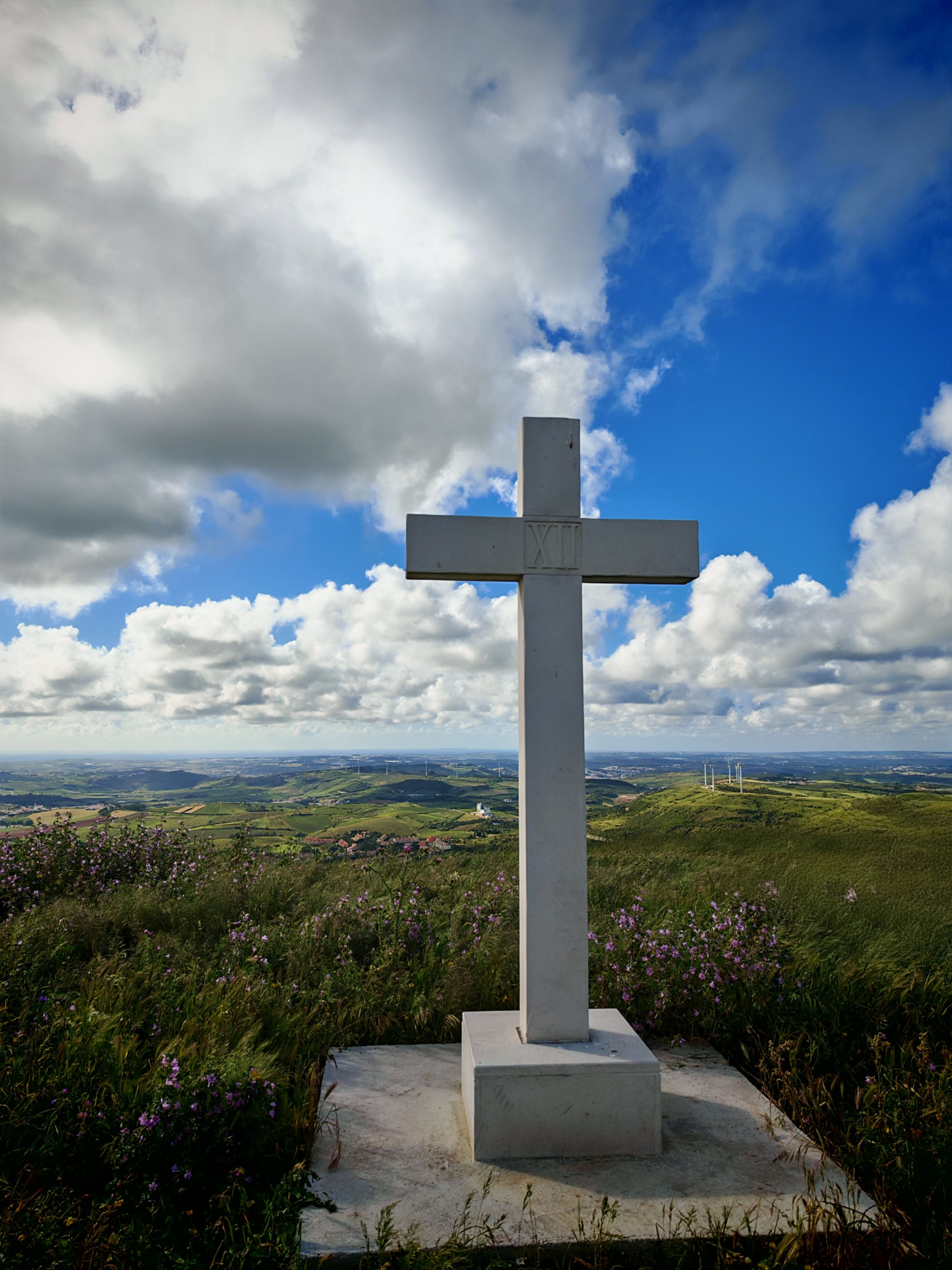 Serene Hilltop Cross Against Blue Sky · Free Stock Photo