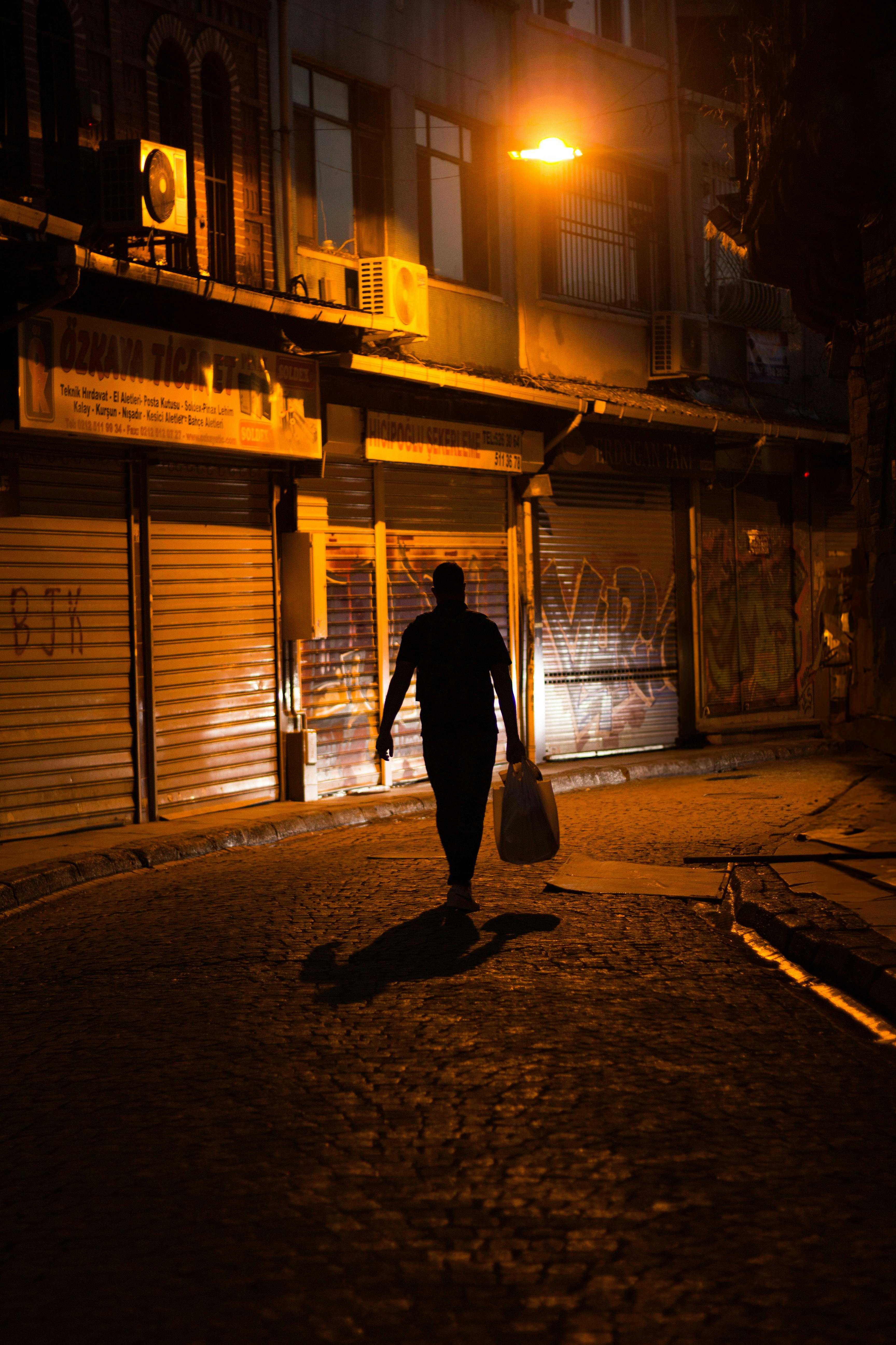 Silhouette Of Man Standing Under Lamp Post · Free Stock Photo