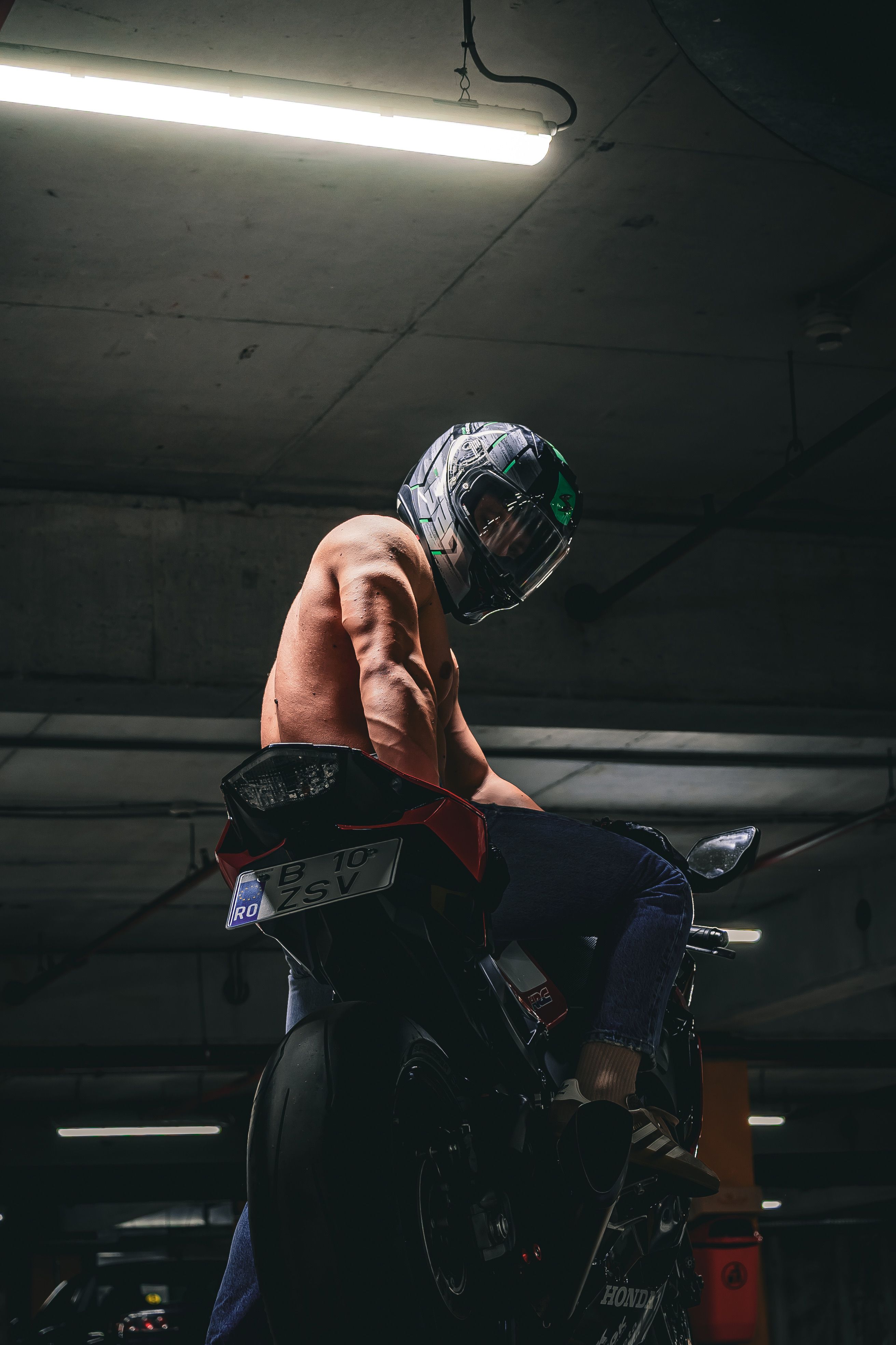 Shirtless Biker on Motorcycle in Dimly Lit Garage · Free Stock Photo