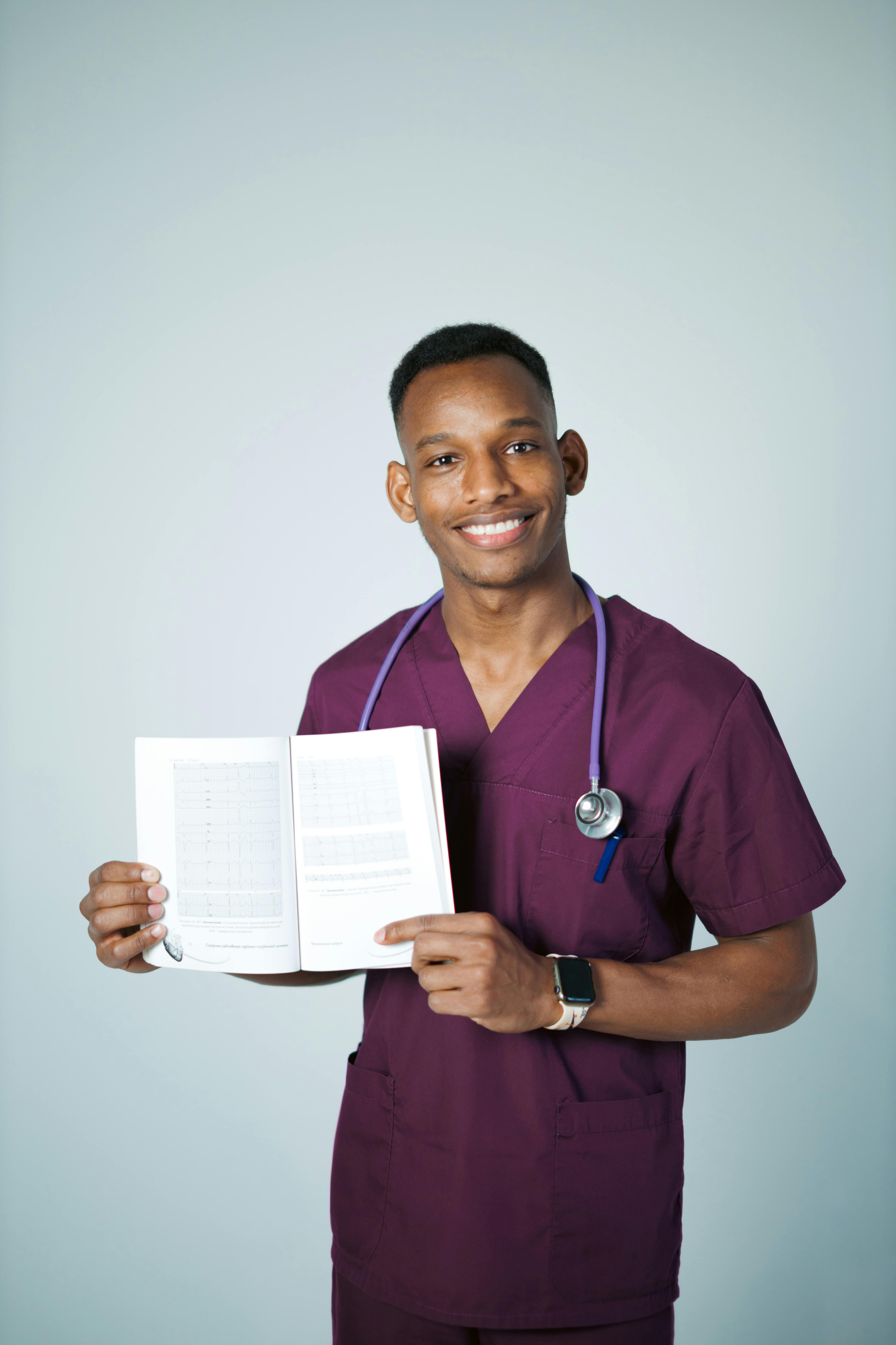 Smiling Medical Professional with Stethoscope and Book · Free Stock Photo