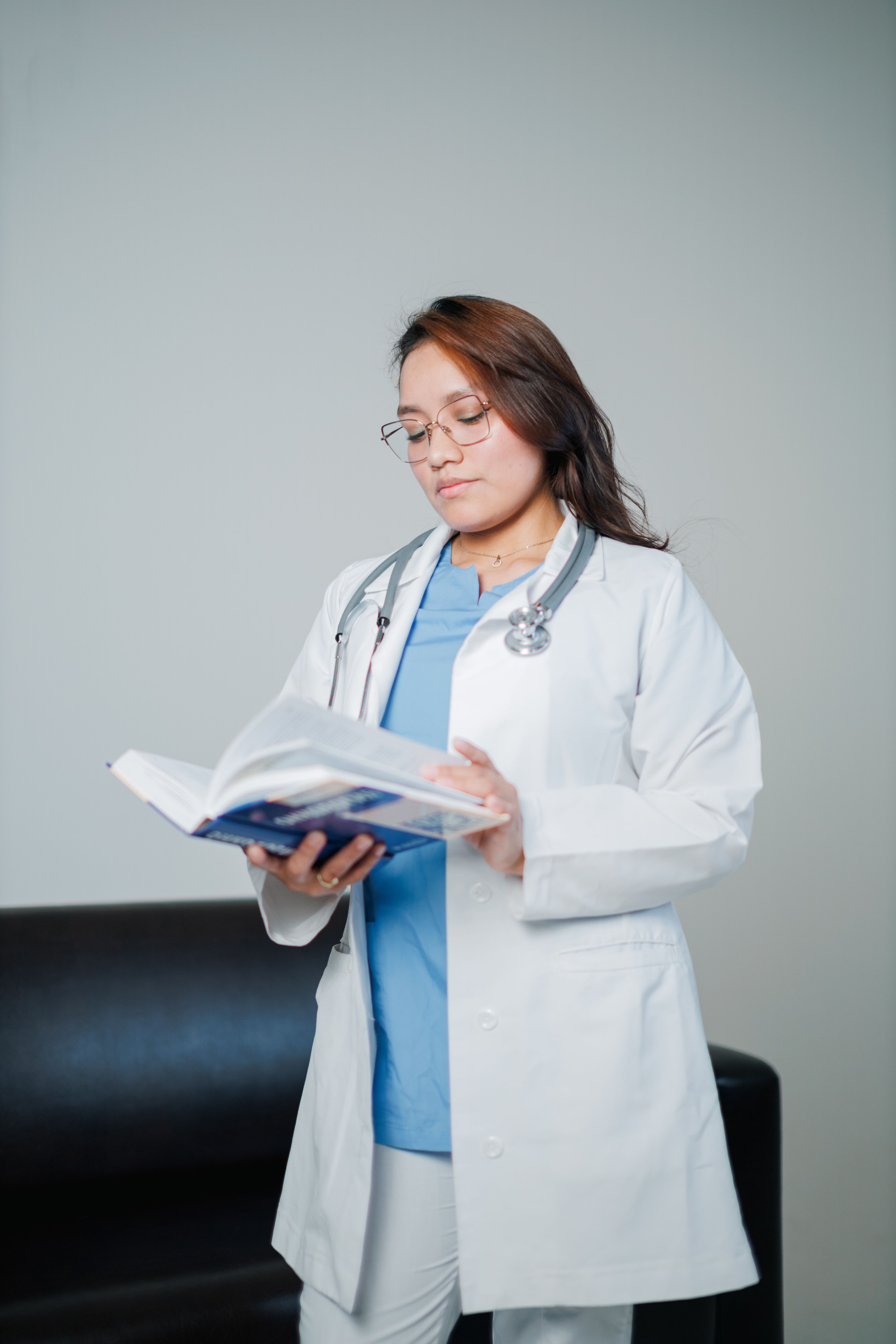 Confident Doctor Reviewing Medical Textbook · Free Stock Photo