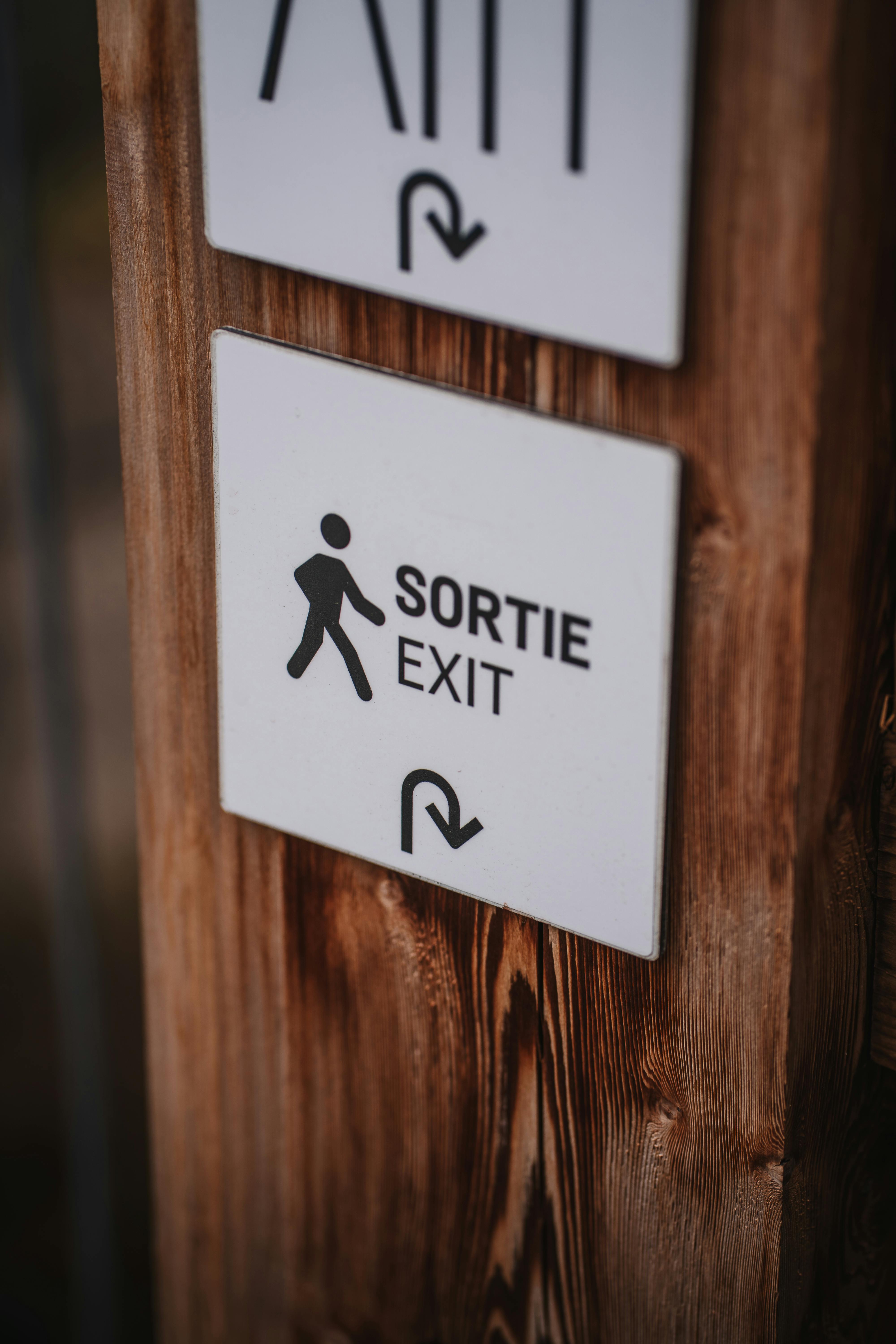 Wooden Post with Sortie Exit Sign · Free Stock Photo