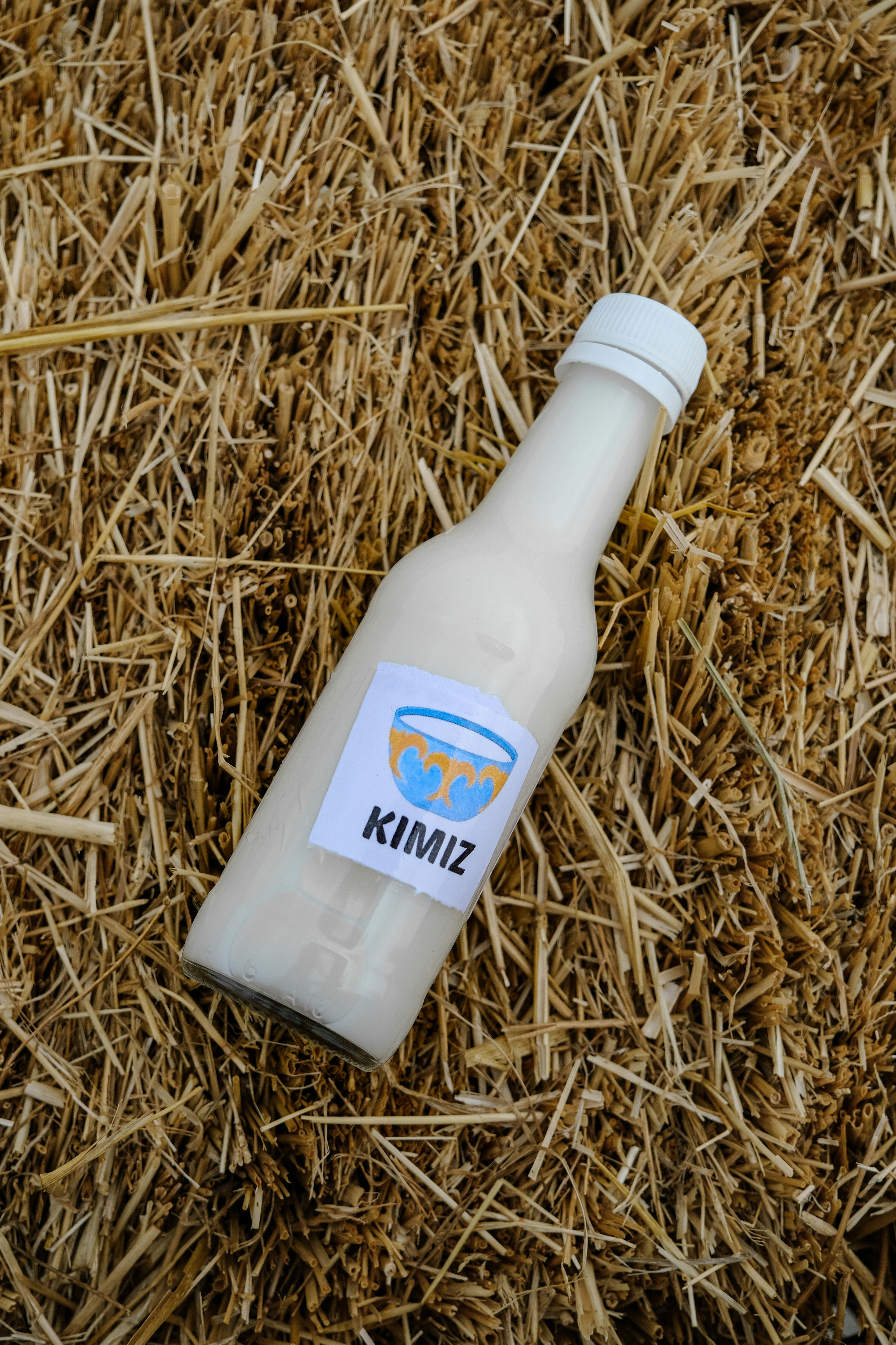 Bottle of Kumis on Straw Bale for Fermented Drink · Free Stock Photo
