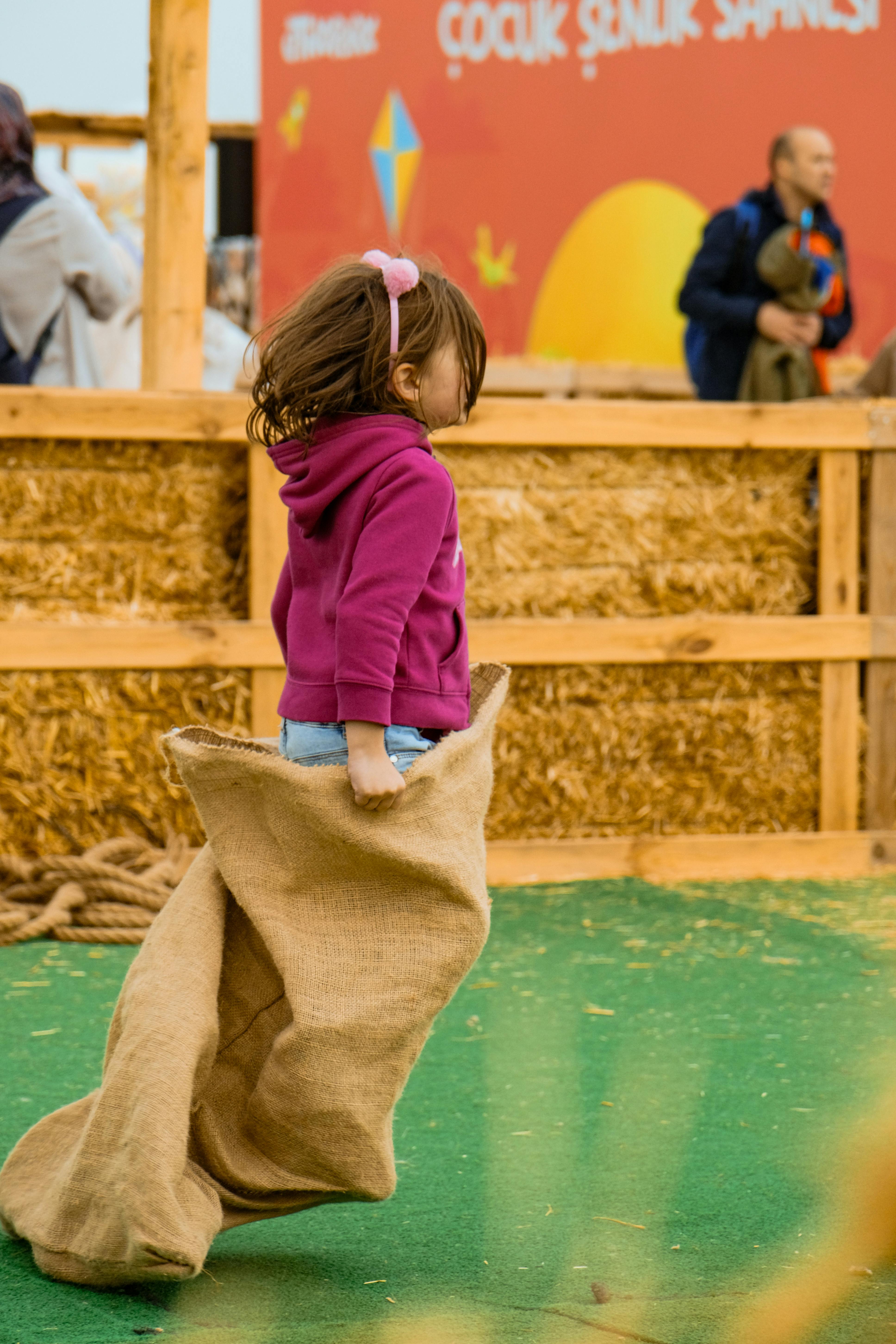 Child Enjoying Sack Race at Outdoor Festival · Free Stock Photo