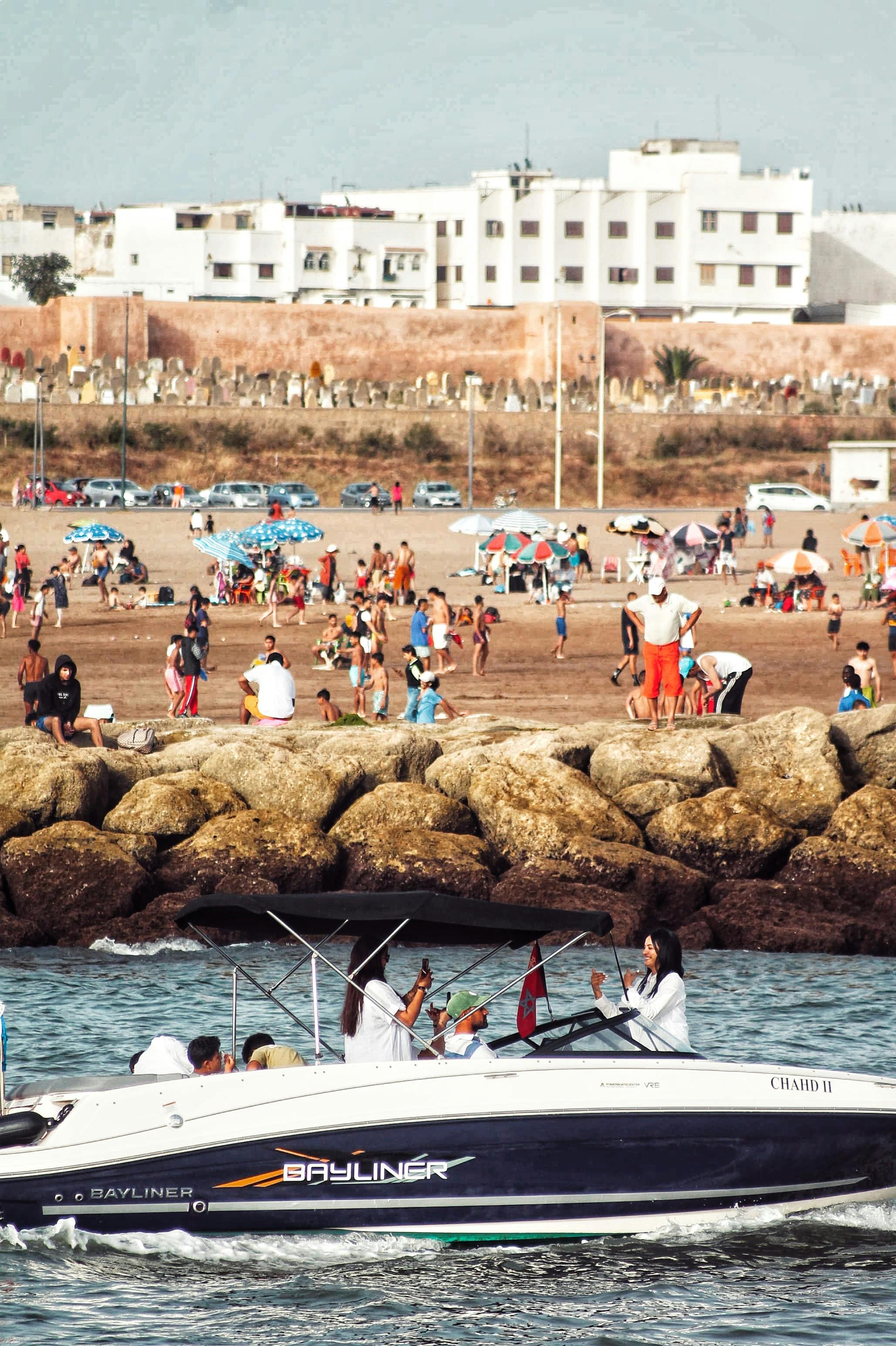 Busy Beach Scene with Boat and Crowds · Free Stock Photo