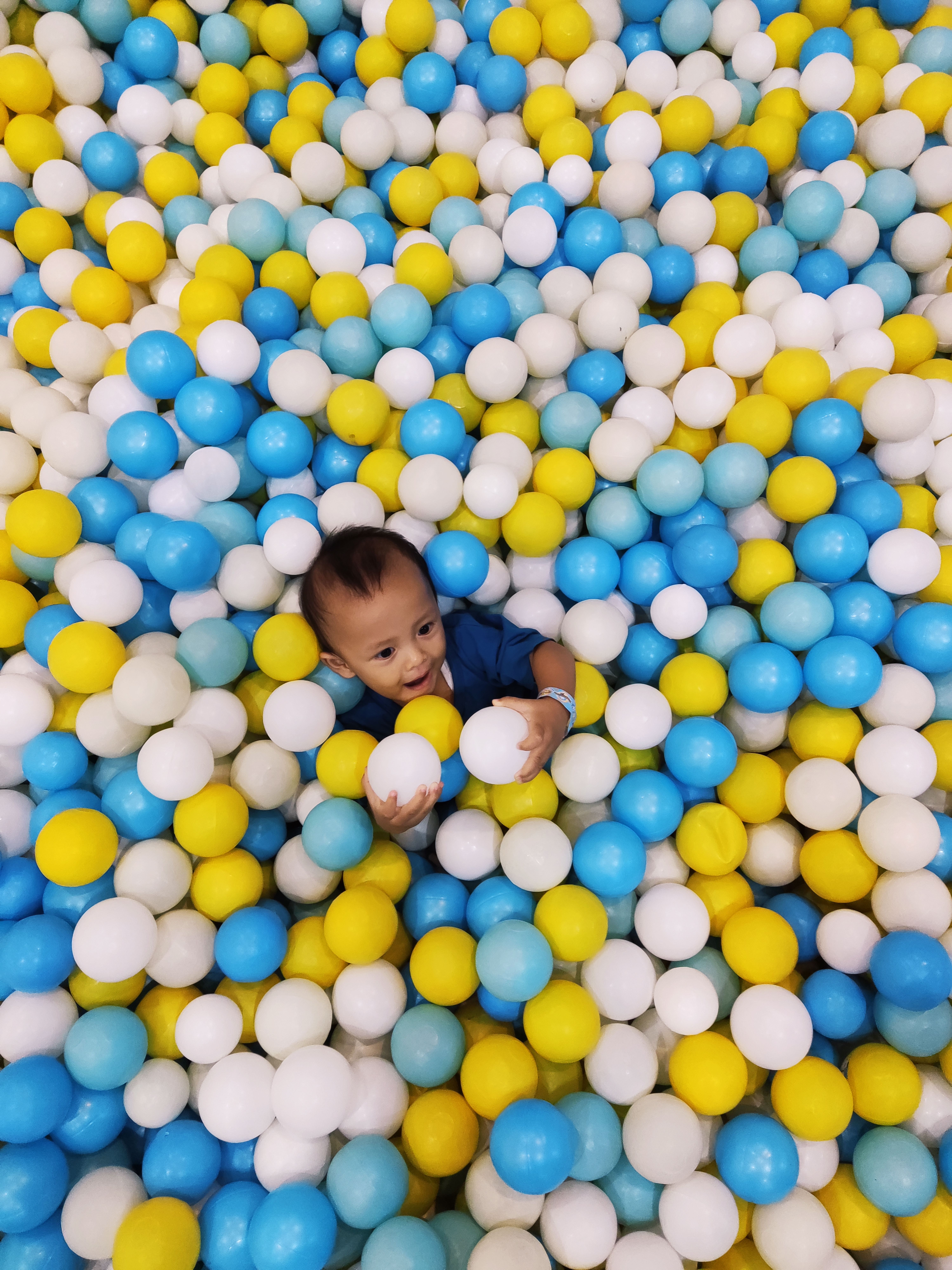 Joyful Baby in a Colorful Ball Pit in Indonesia · Free Stock Photo