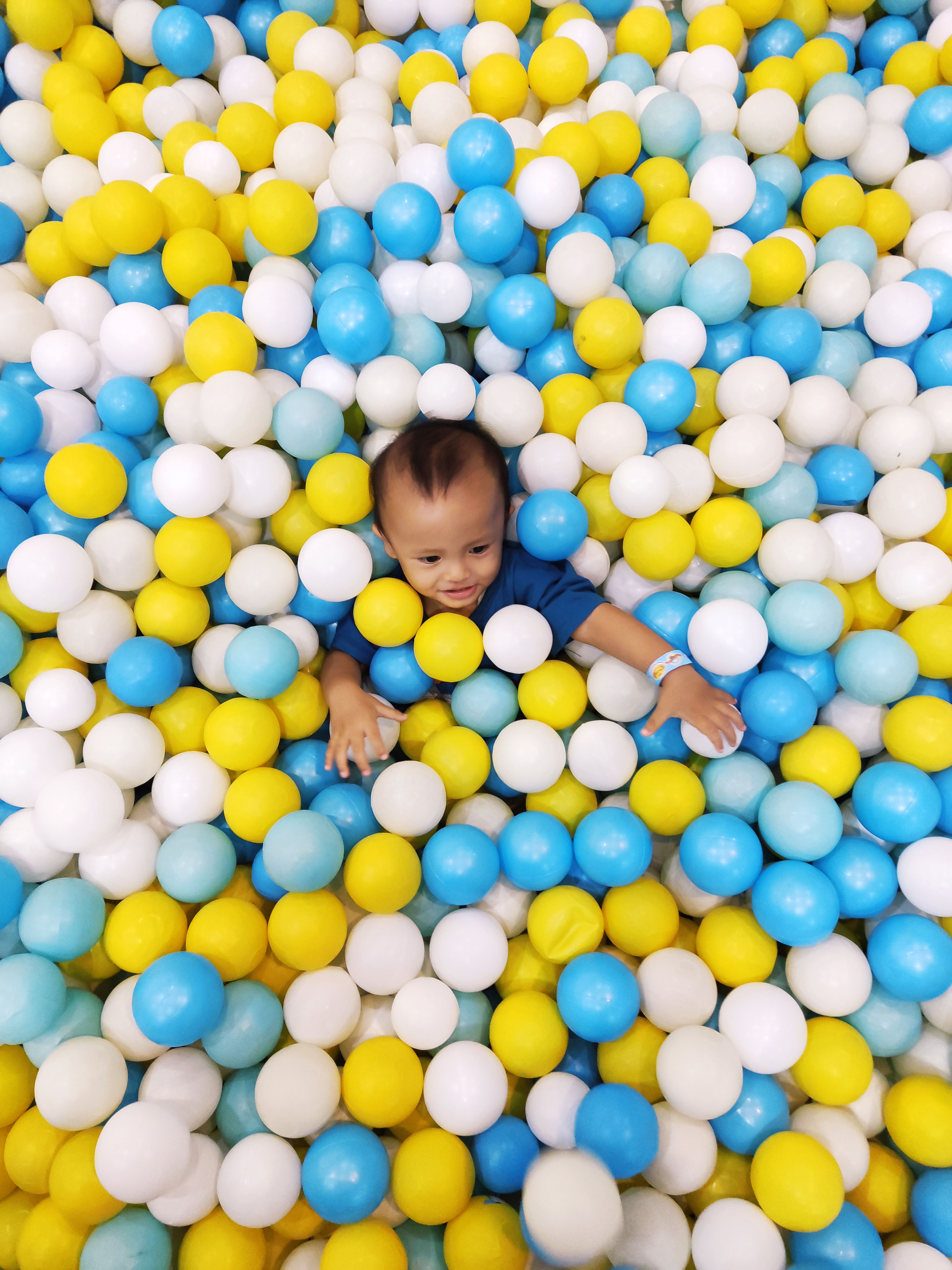Adorable baby playing in colorful ball pit · Free Stock Photo