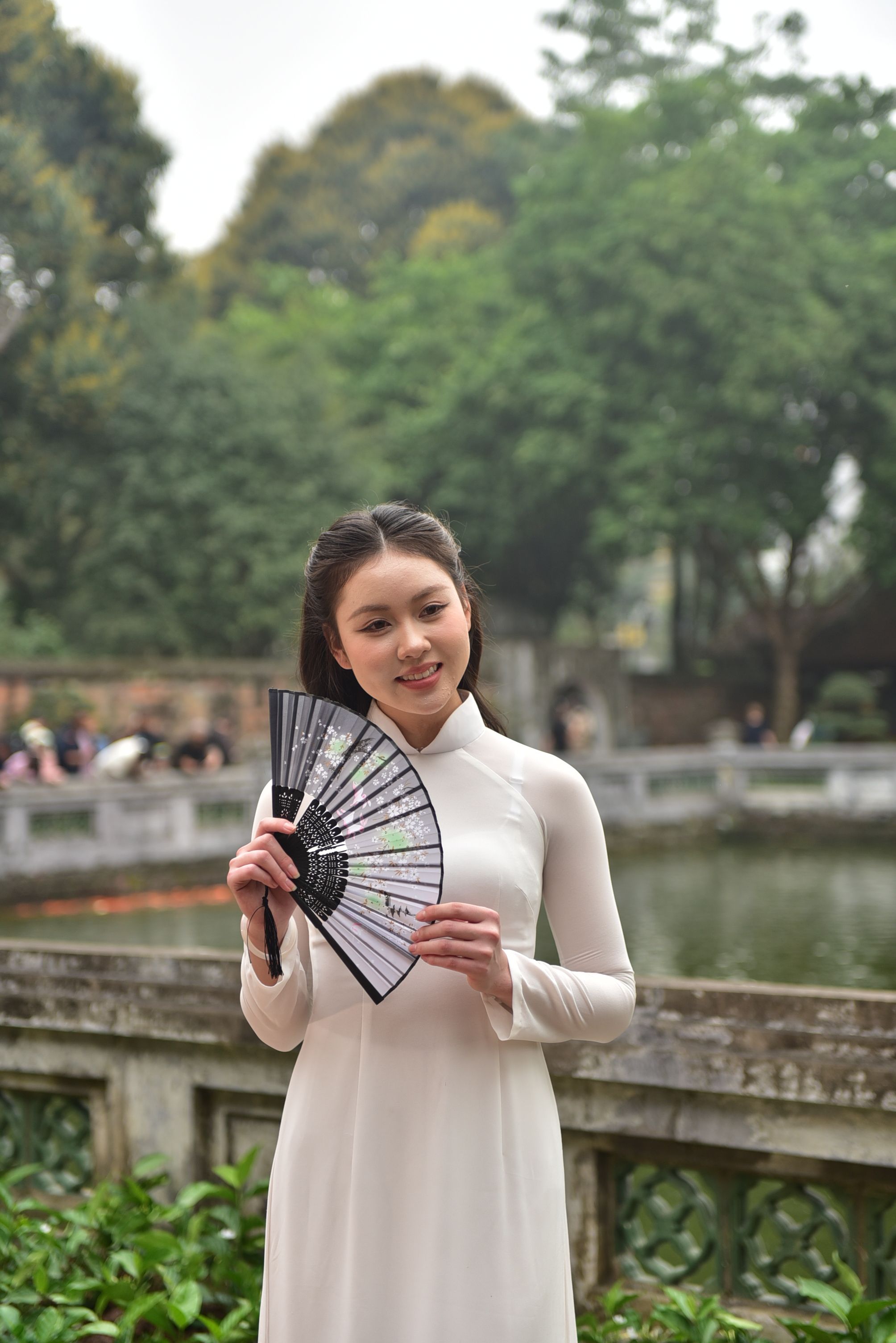 Young Woman Holding a Traditional Fan Outdoors · Free Stock Photo