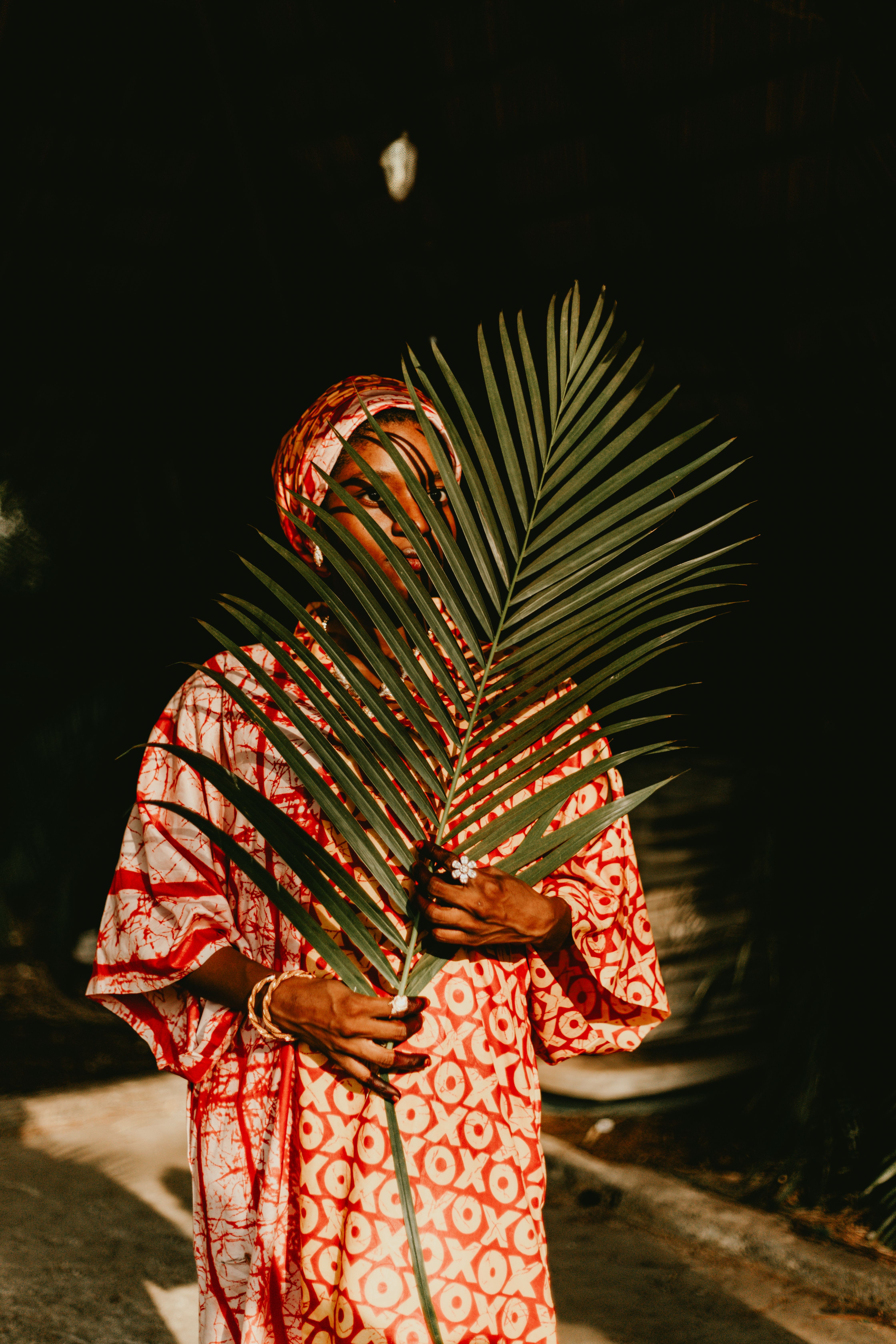 Woman in Traditional Dress Holding Palm Leaf · Free Stock Photo