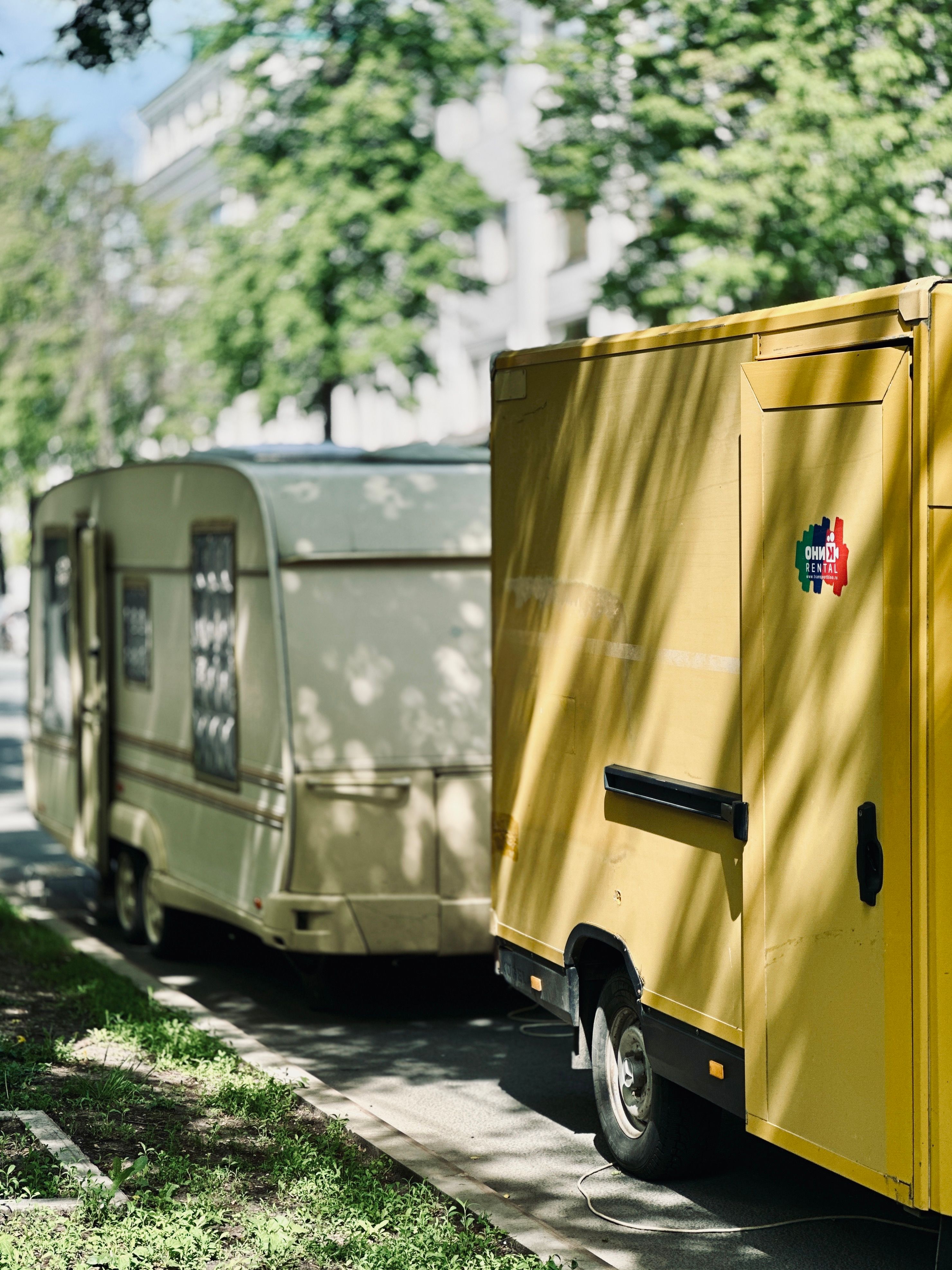 Yellow Van and Caravan Parked on Tree-Lined Street · Free Stock Photo