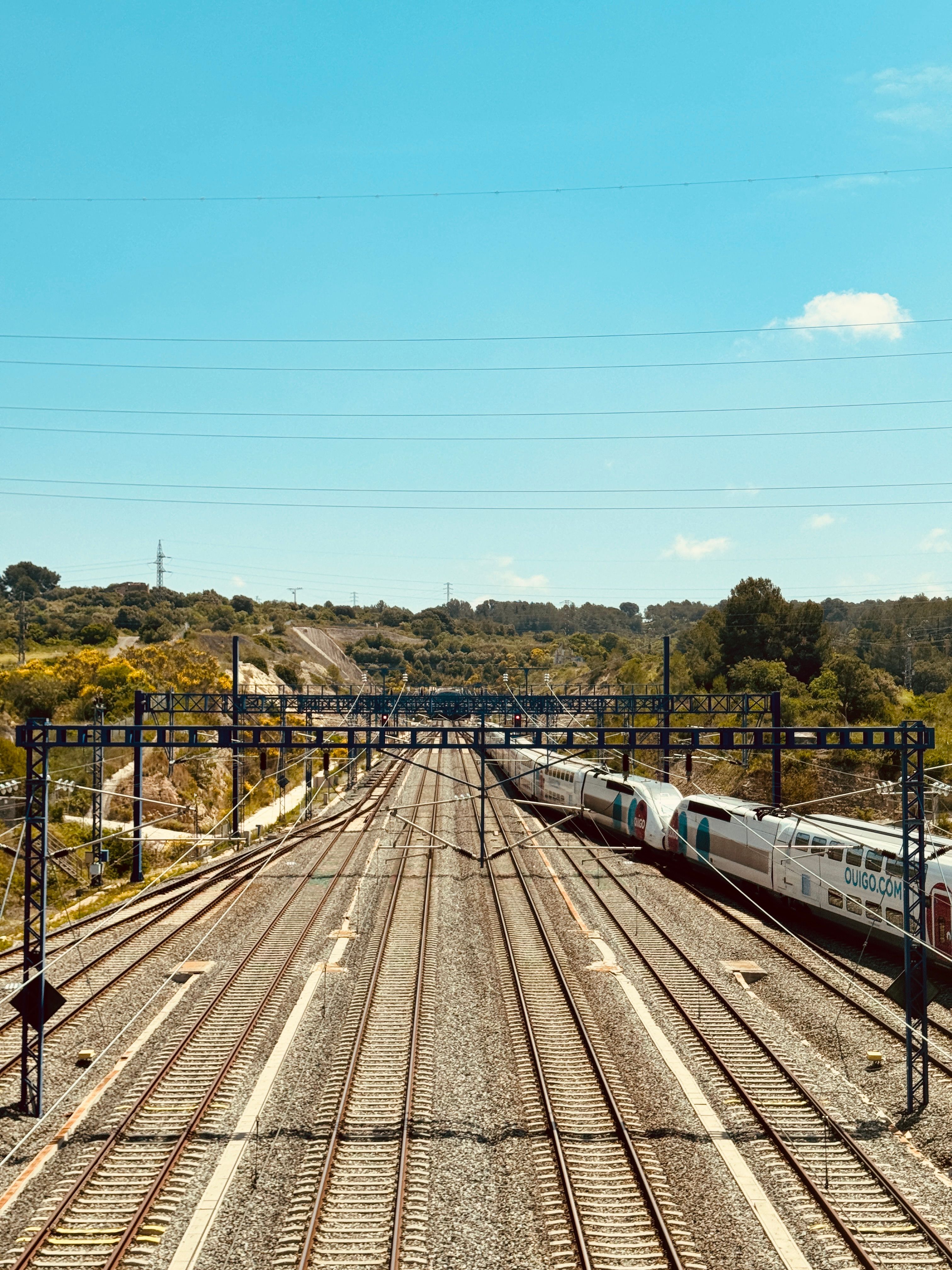 Railway Tracks with High-Speed Train Under Blue Sky · Free Stock Photo