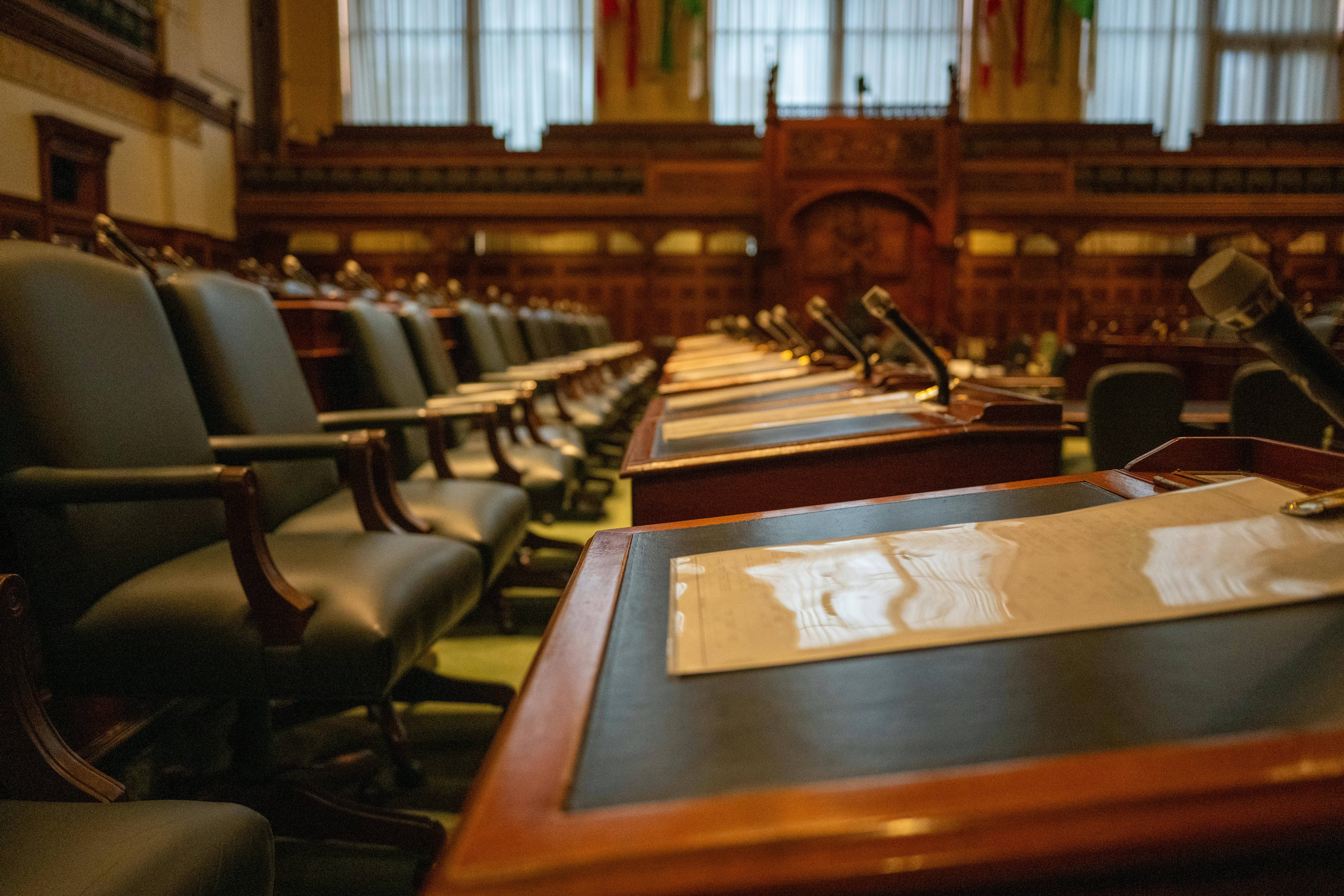 Empty Government Chamber with Desk Rows and Microphones · Free Stock Photo