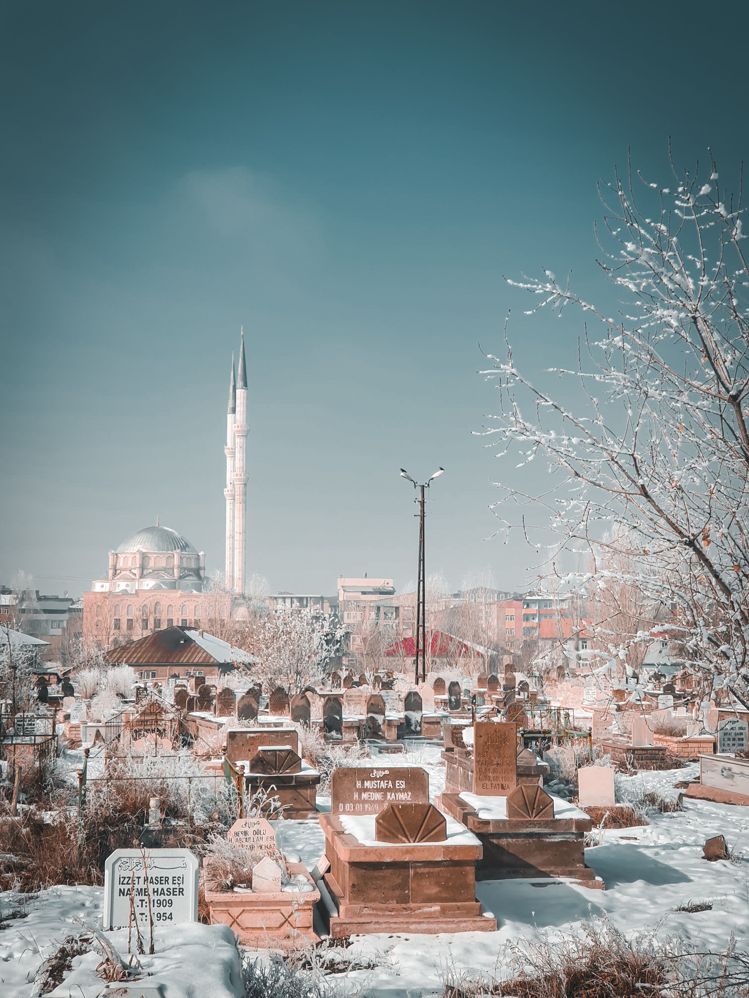Snowy Cemetery with Mosque in the Background · Free Stock Photo