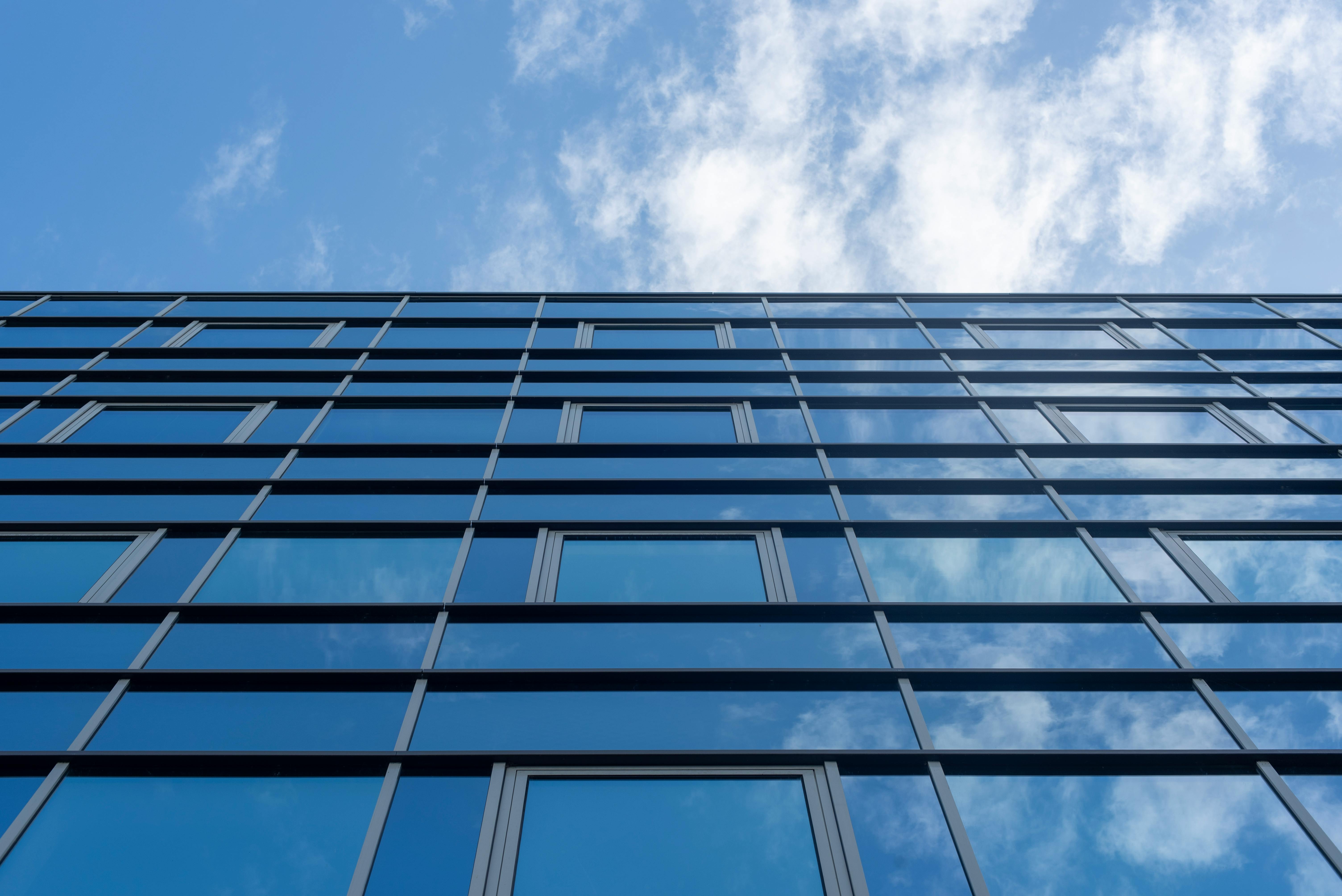 Modern Glass Building Facade Reflecting Sky · Free Stock Photo