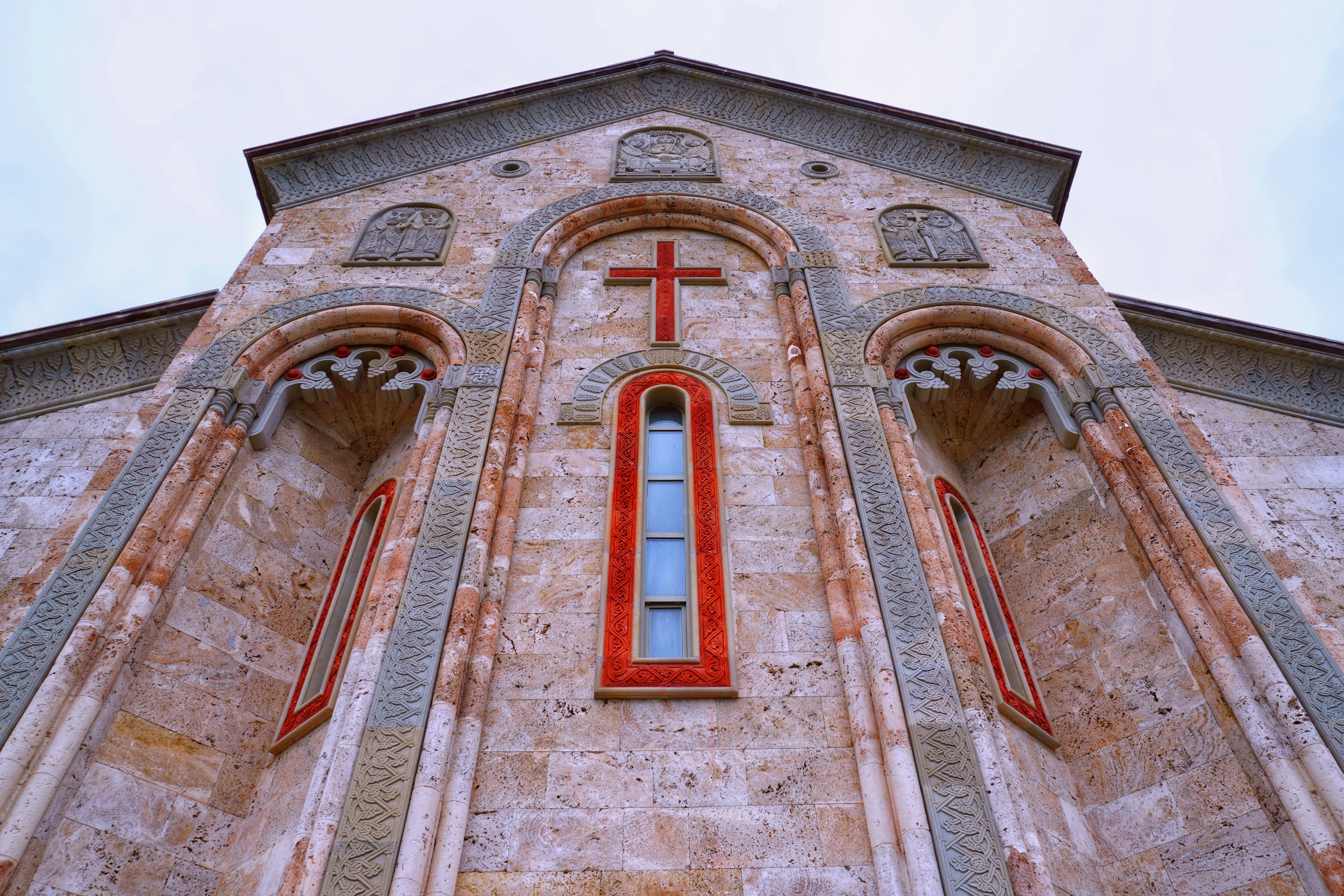 Ornate Church Facade with Red Cross and Windows · Free Stock Photo