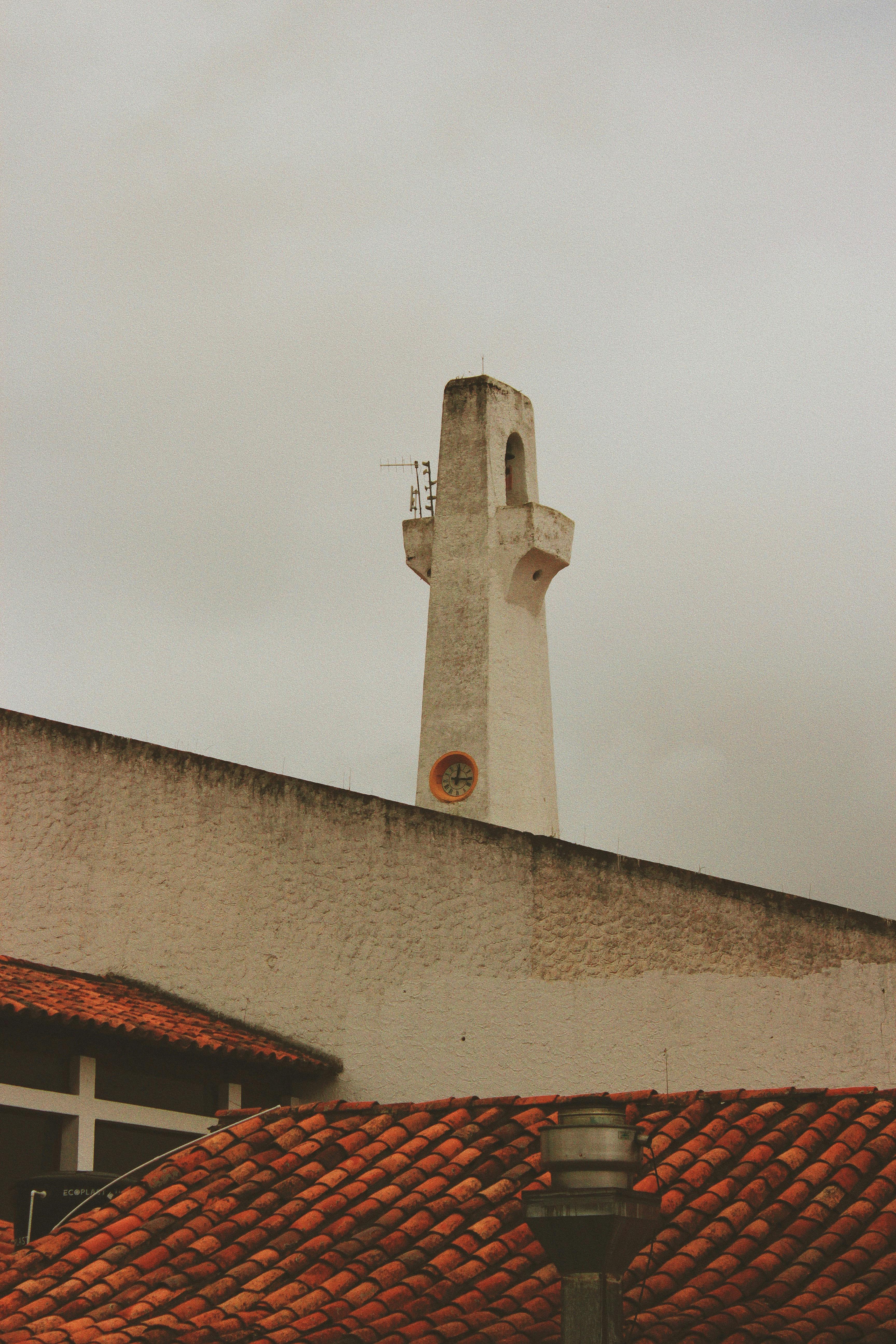 Rustic Tower and Tiled Roof Against Overcast Sky · Free Stock Photo