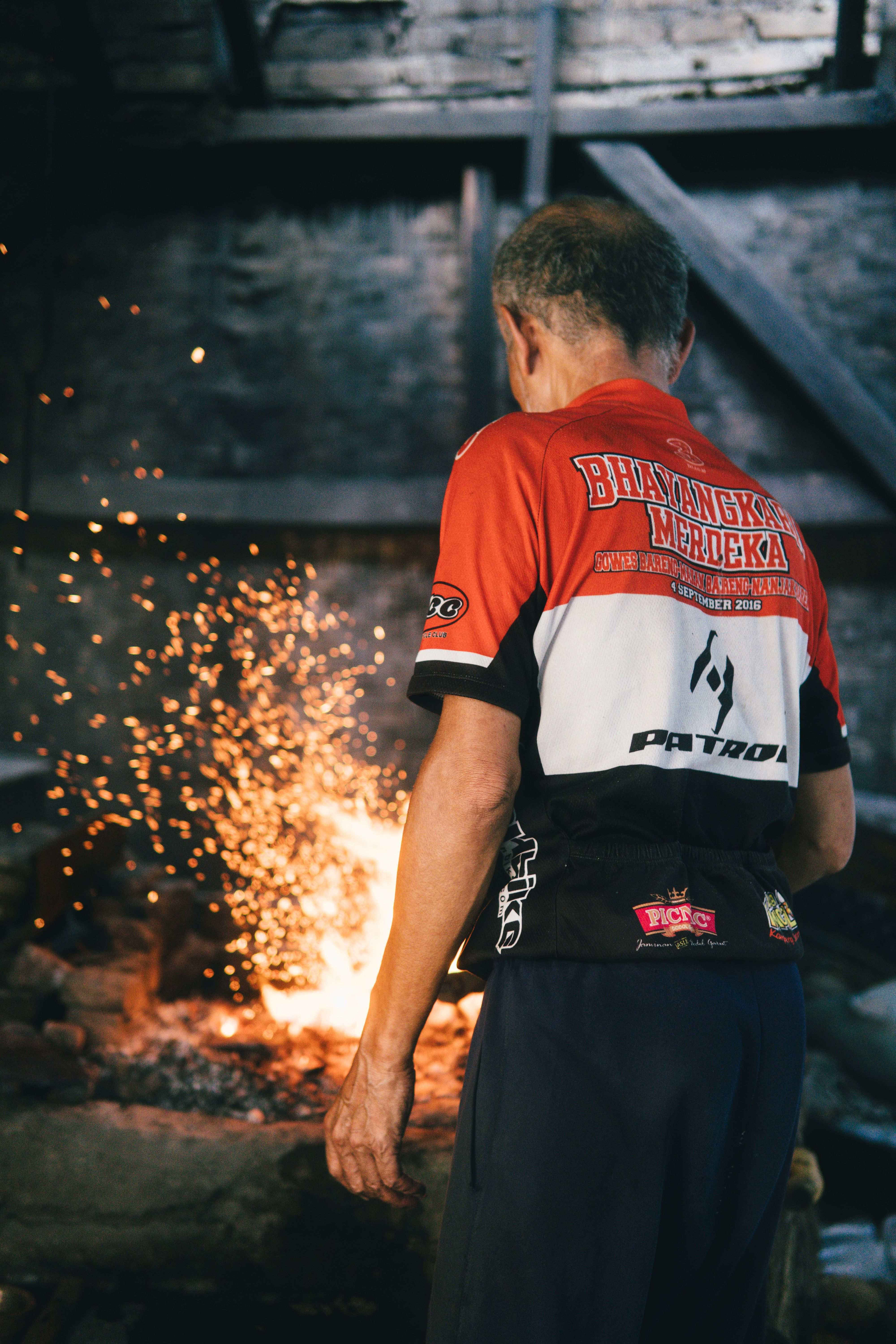 Man Standing Near Fire in Workshop with Sparks · Free Stock Photo