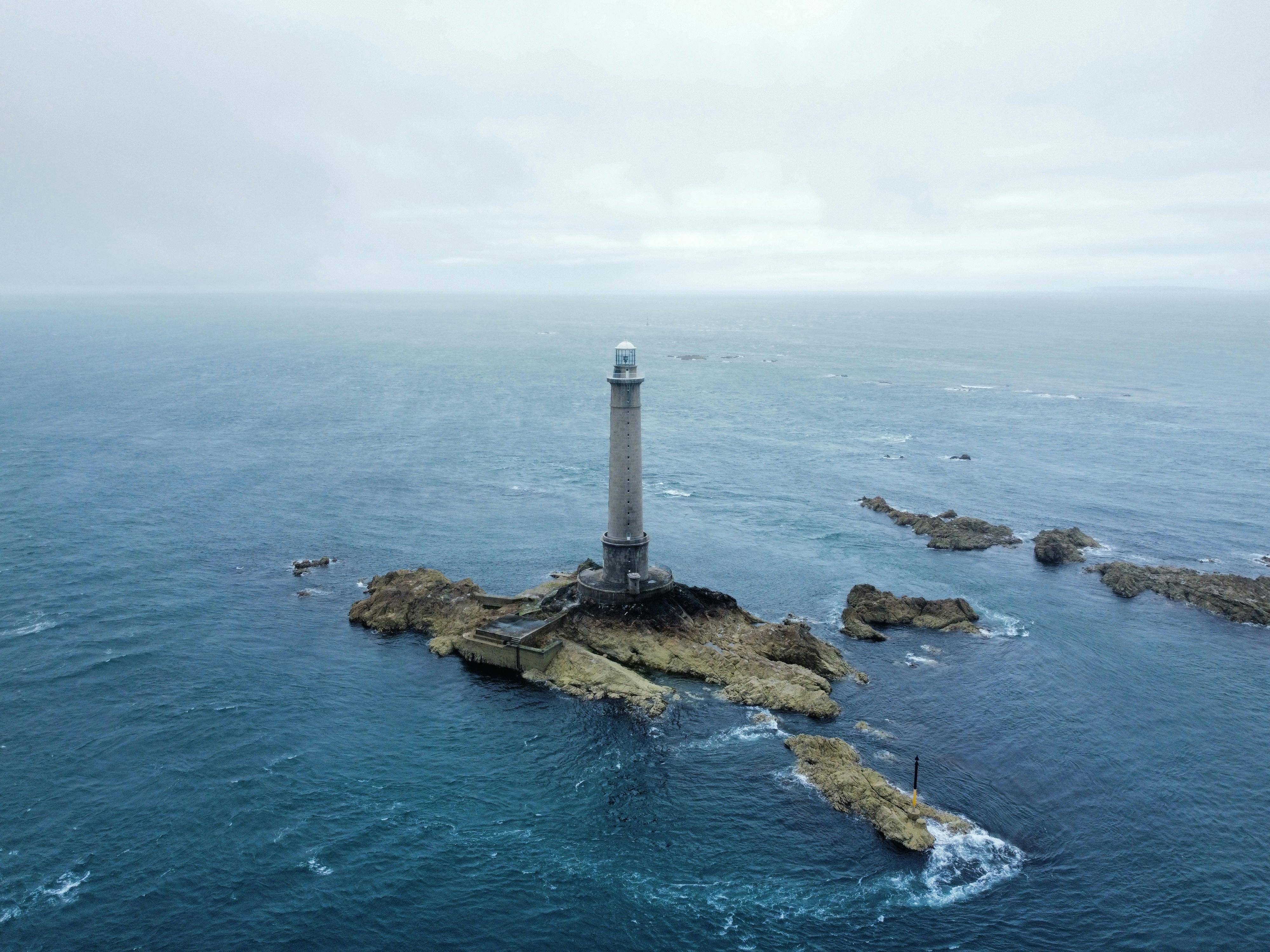 Dramatic Lighthouse on Rocky Coastline · Free Stock Photo