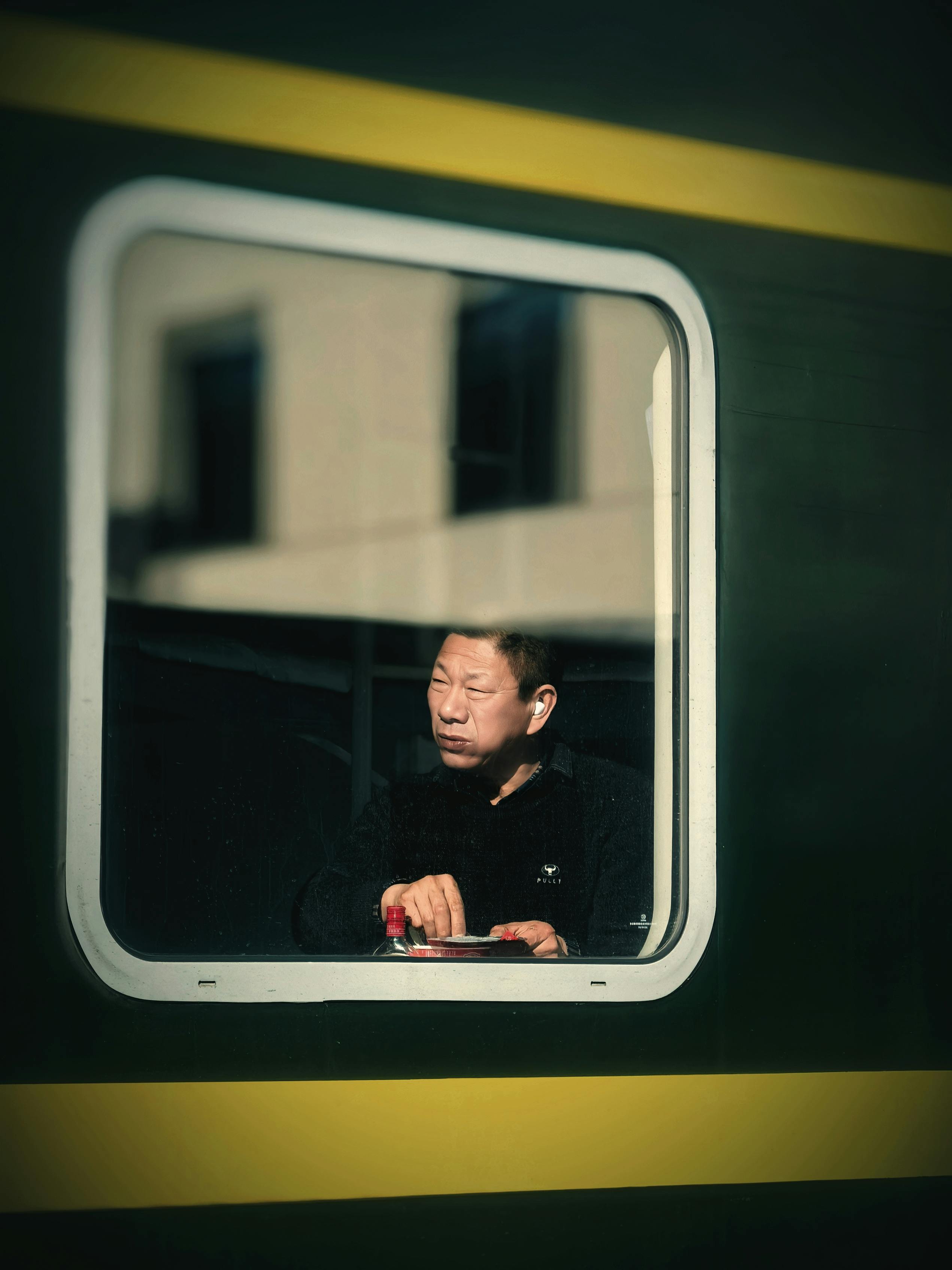 Man Looking Out Train Window in Thoughtful Gaze · Free Stock Photo