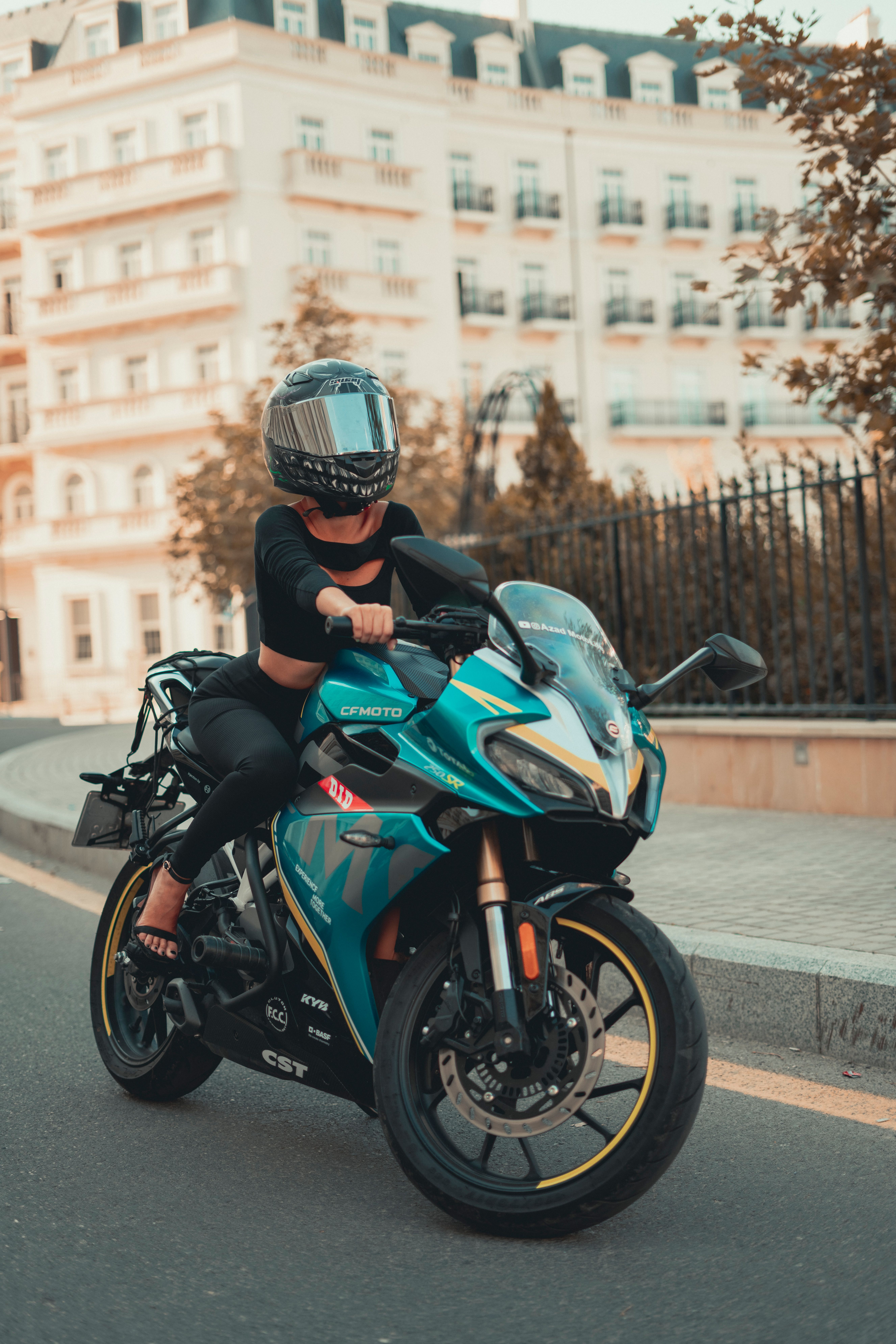 Woman Riding Motorcycle on Urban Street · Free Stock Photo
