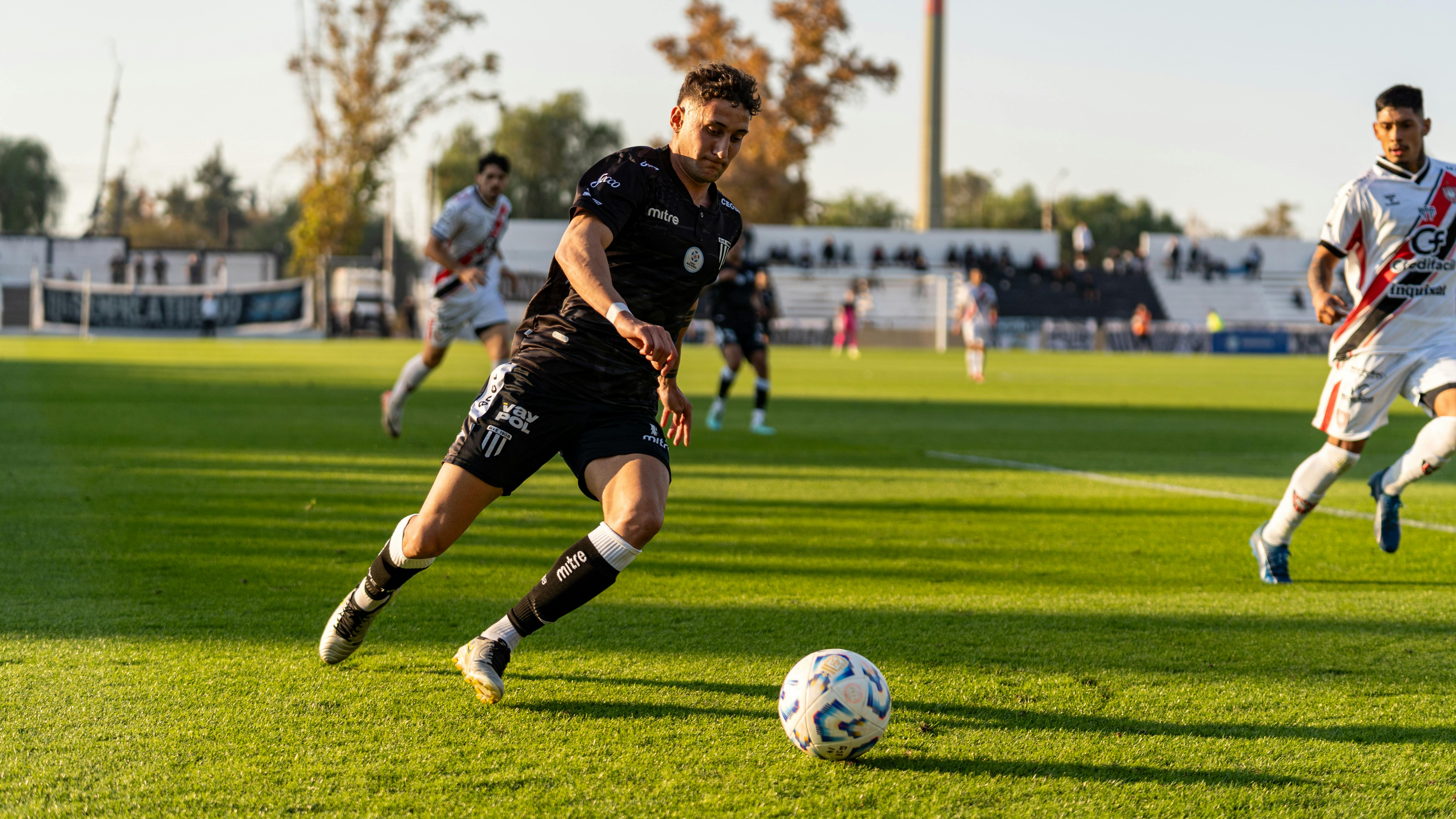 Professional Football Match in Action During Sunset · Free Stock Photo