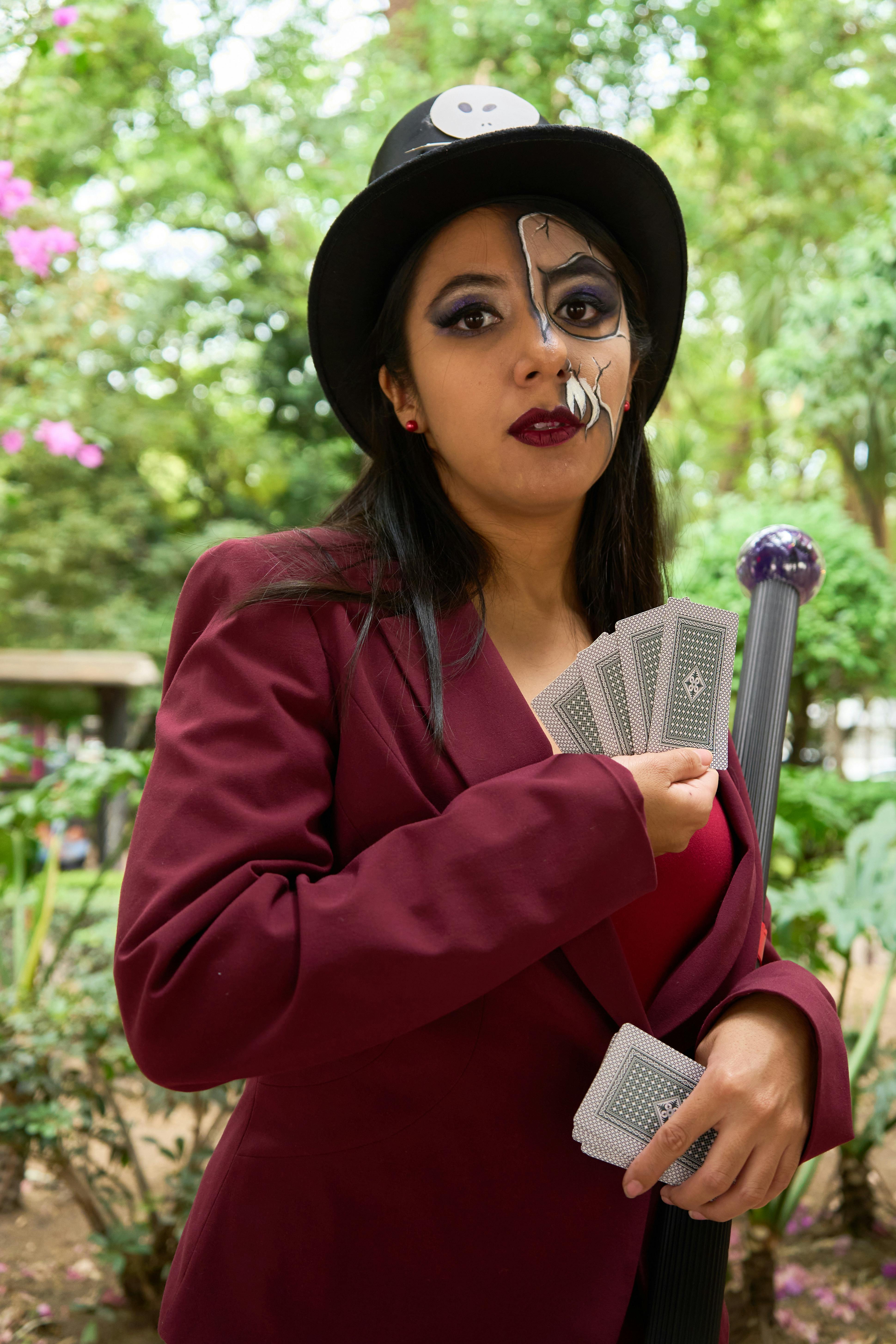 Woman in Costume Holding Playing Cards Outdoors · Free Stock Photo