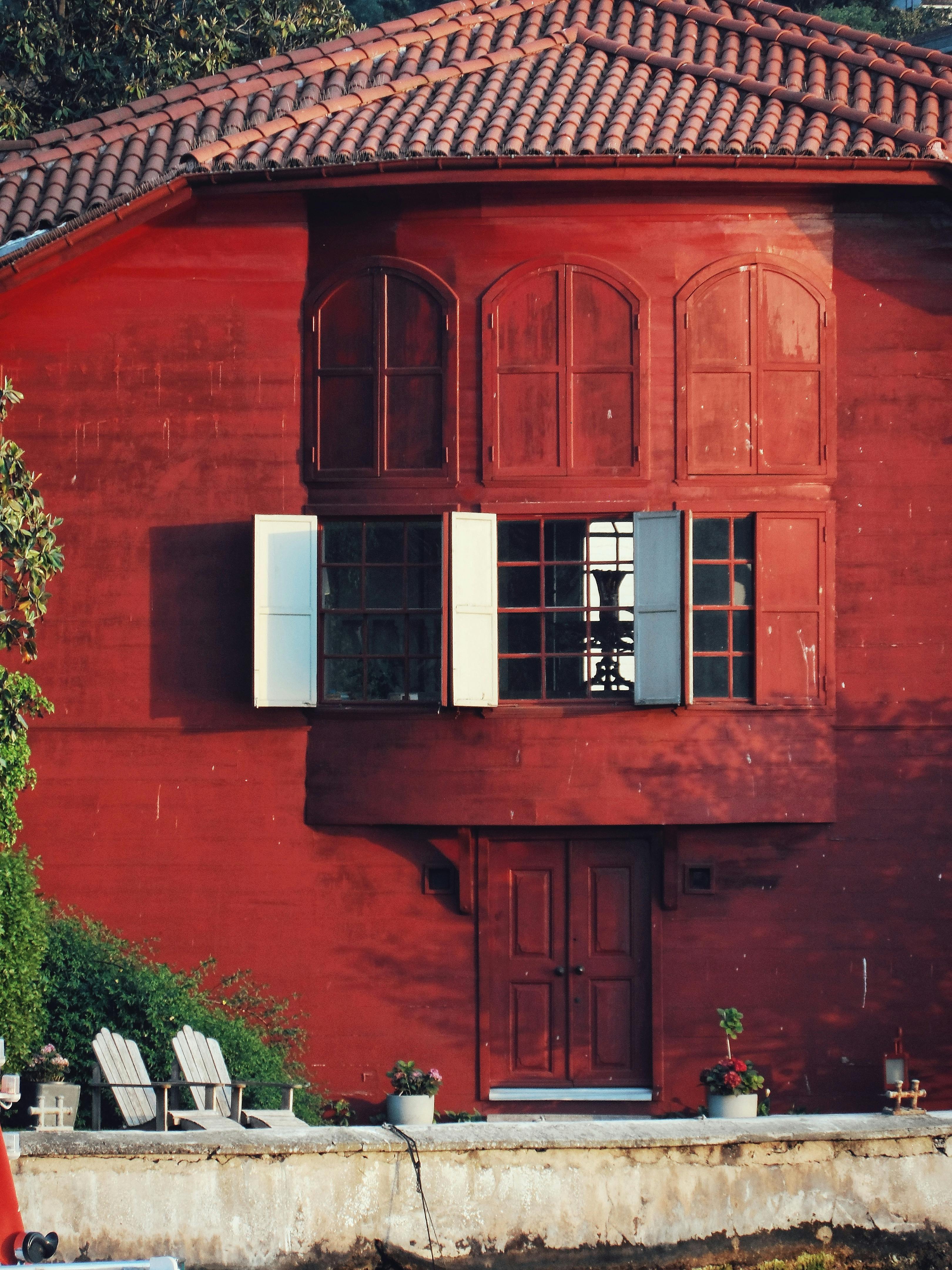 Rustic Red House with White Shutters by the Sea · Free Stock Photo