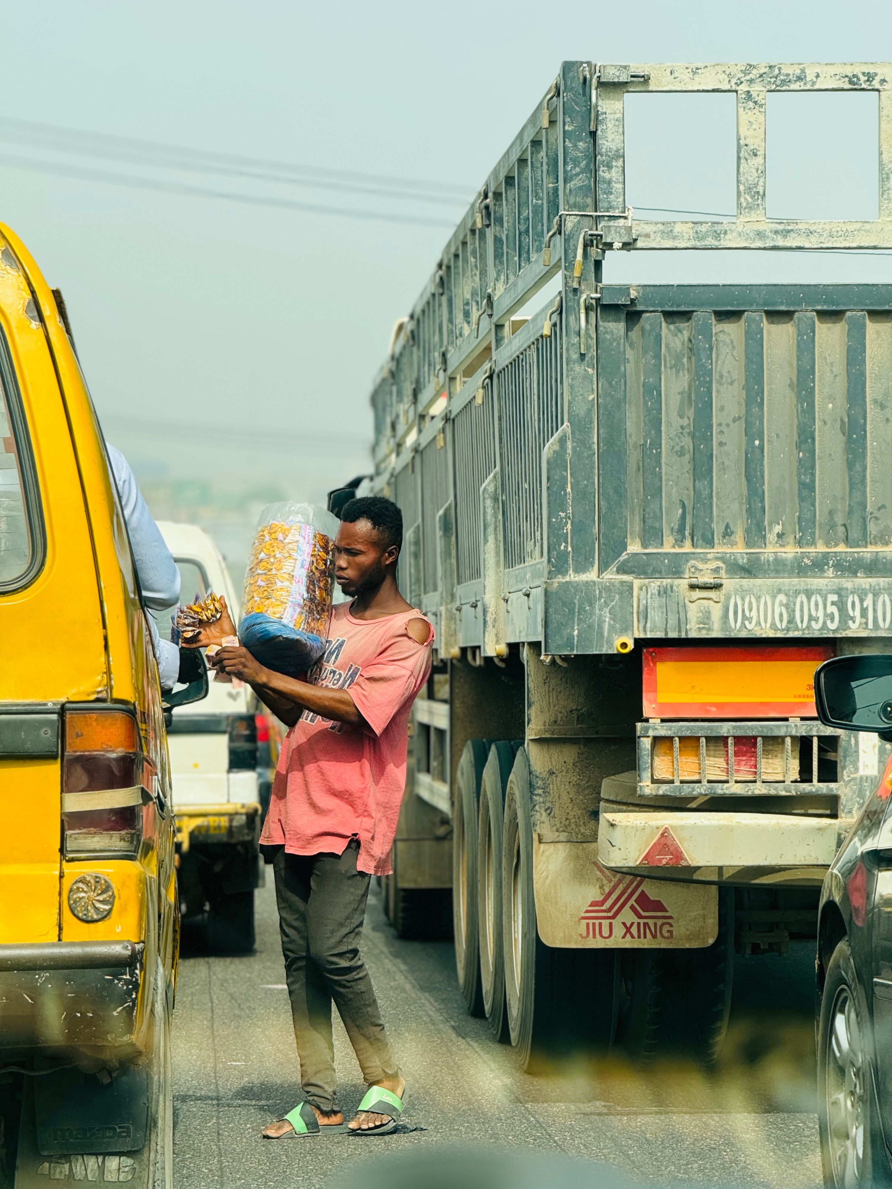 Street Vendor Selling Snacks in Traffic Jam · Free Stock Photo