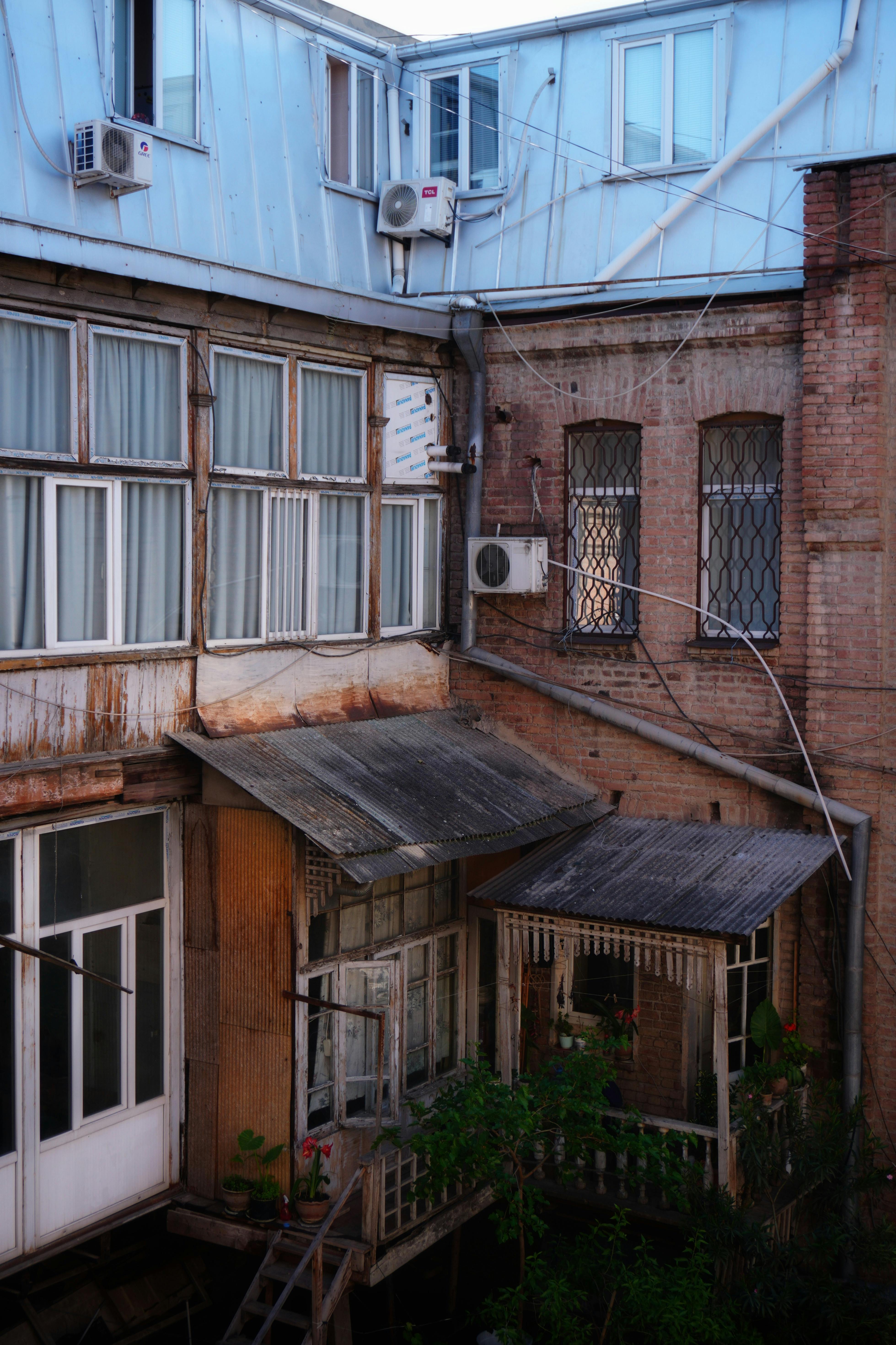Rustic Apartment Building Exterior with Plants · Free Stock Photo