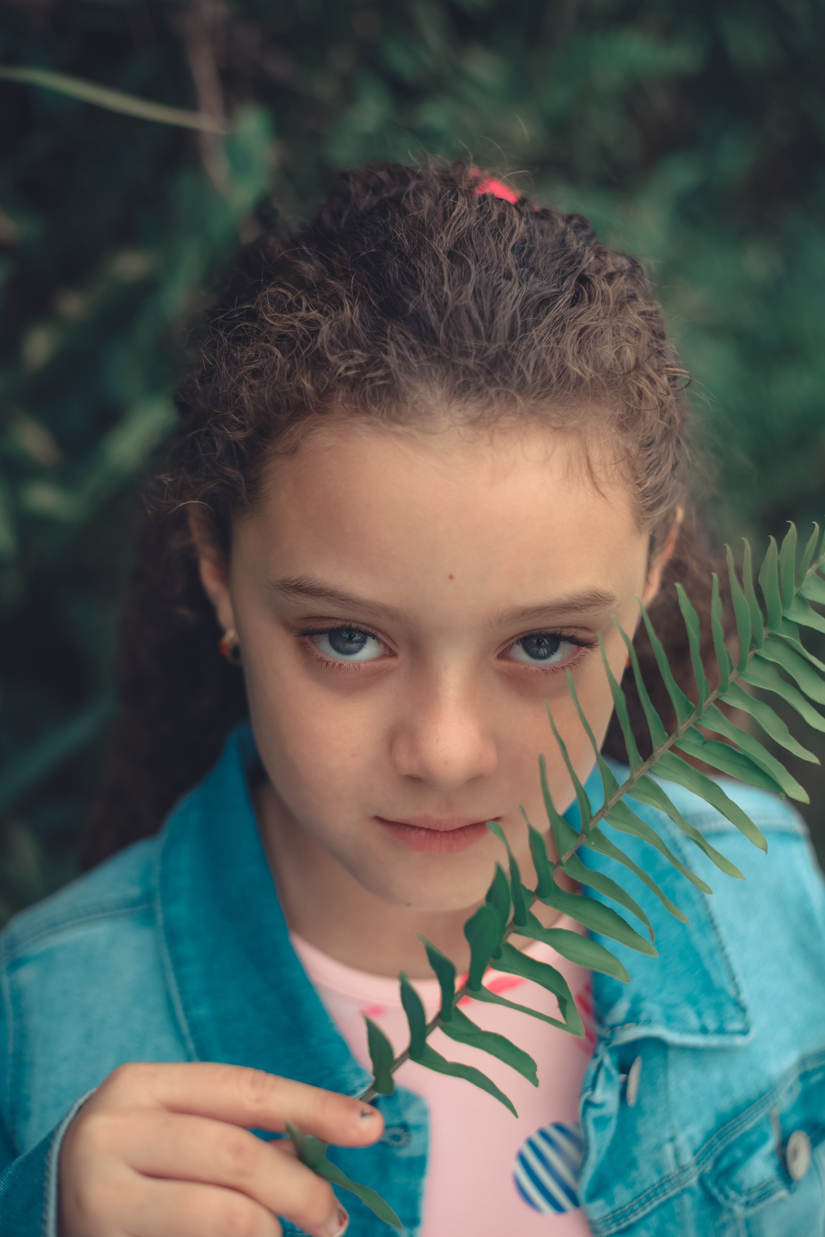 Young Girl Holding Fern in Natural Setting · Free Stock Photo