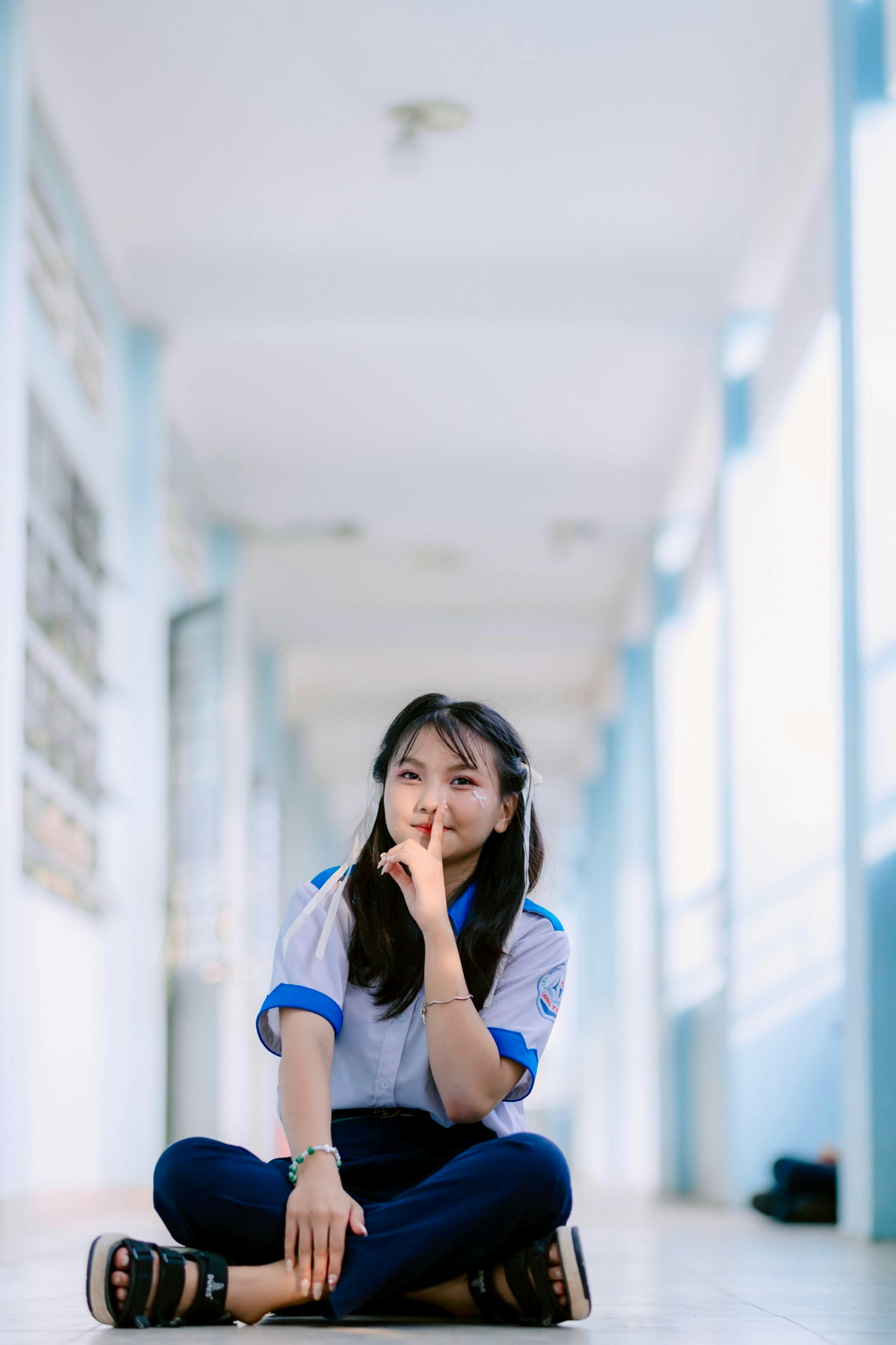 Young Student Sitting in School Hallway · Free Stock Photo