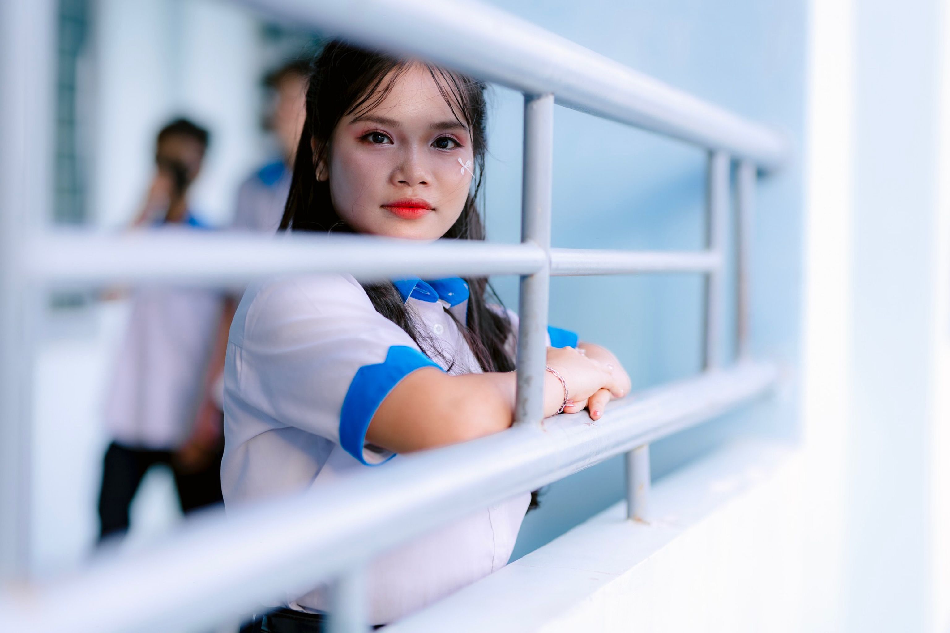 Young woman in school uniform leaning on railing · Free Stock Photo