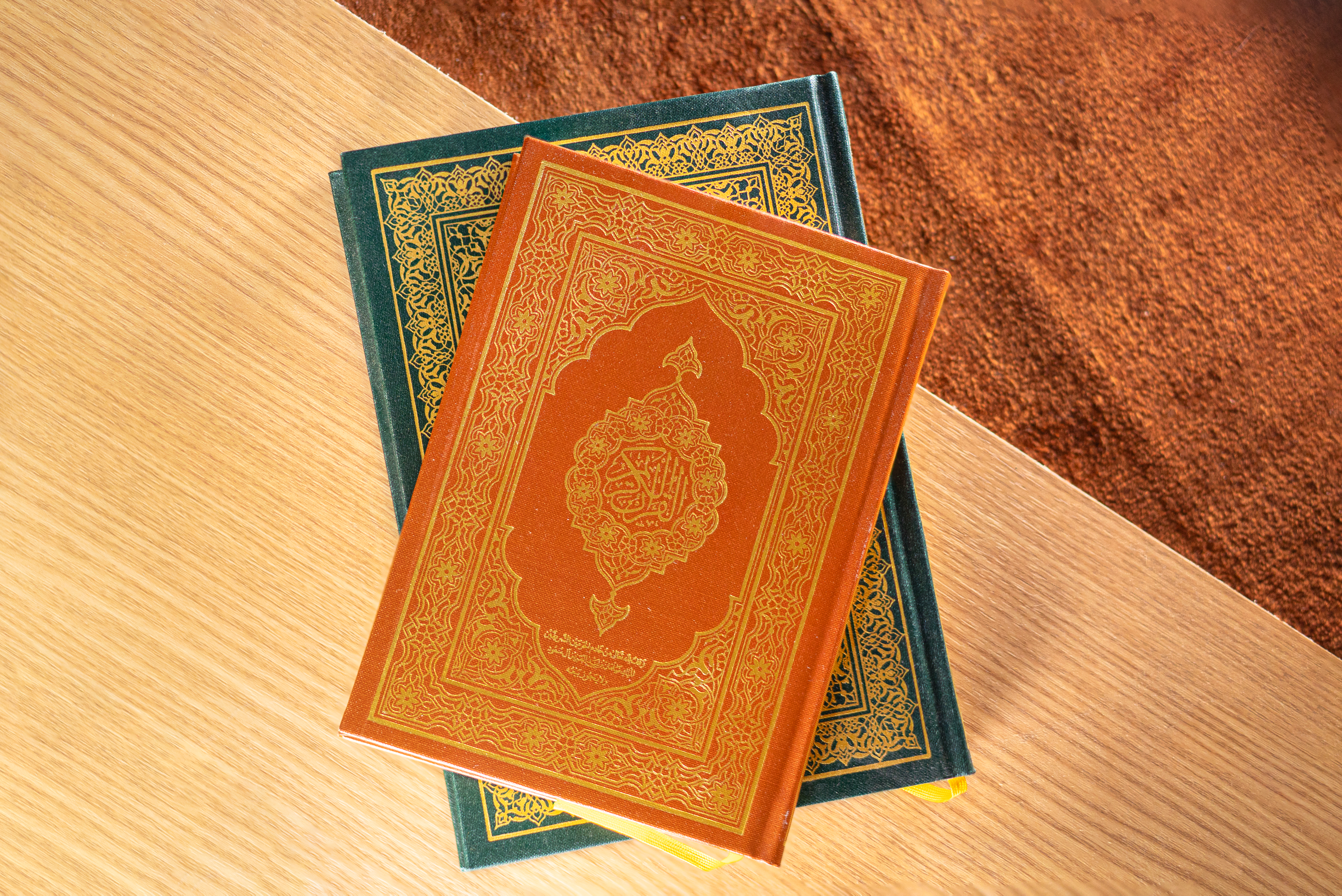 Elegant Quran Covers on Wooden Table · Free Stock Photo