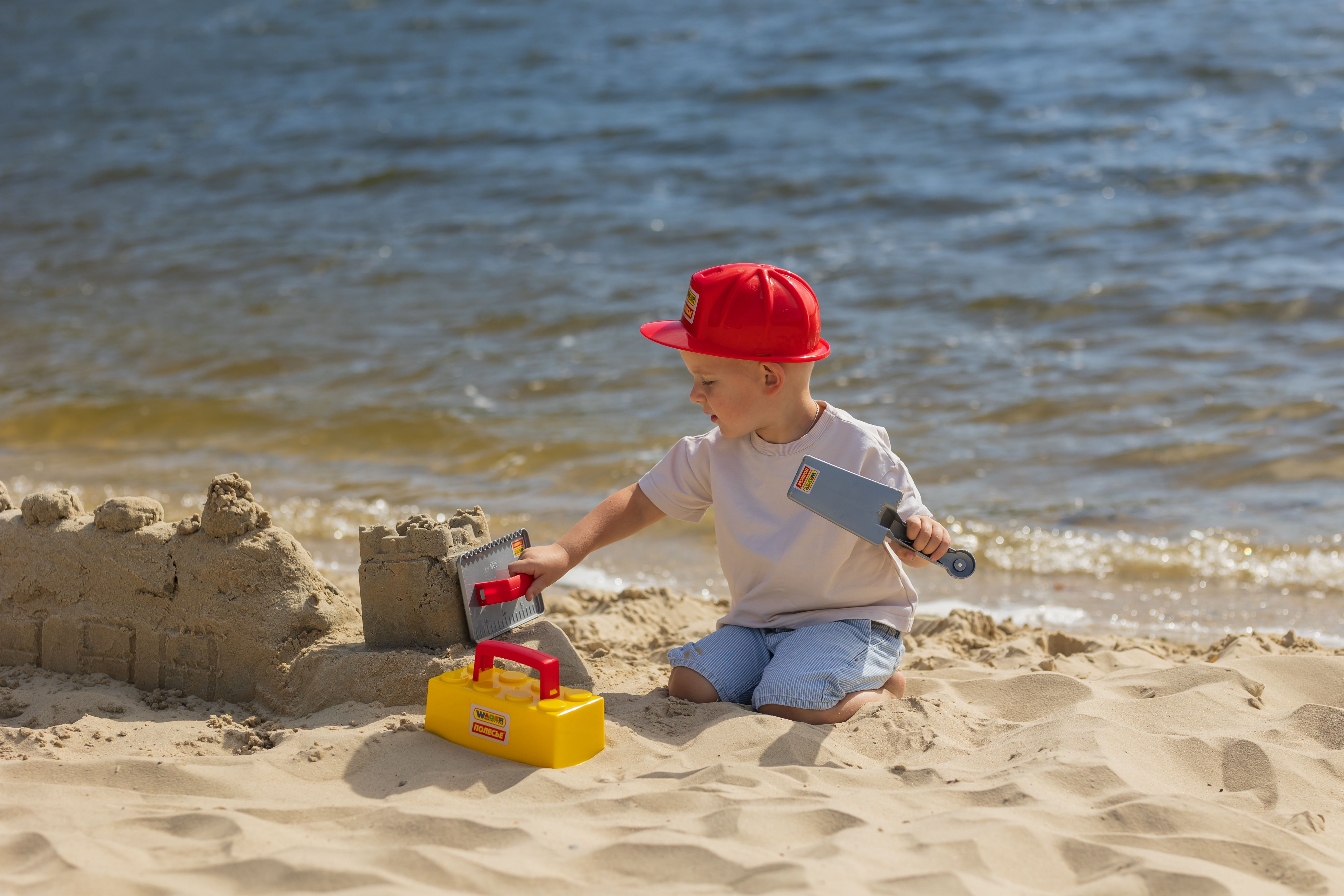 Young Boy Building Sandcastle on Sunny Beach · Free Stock Photo