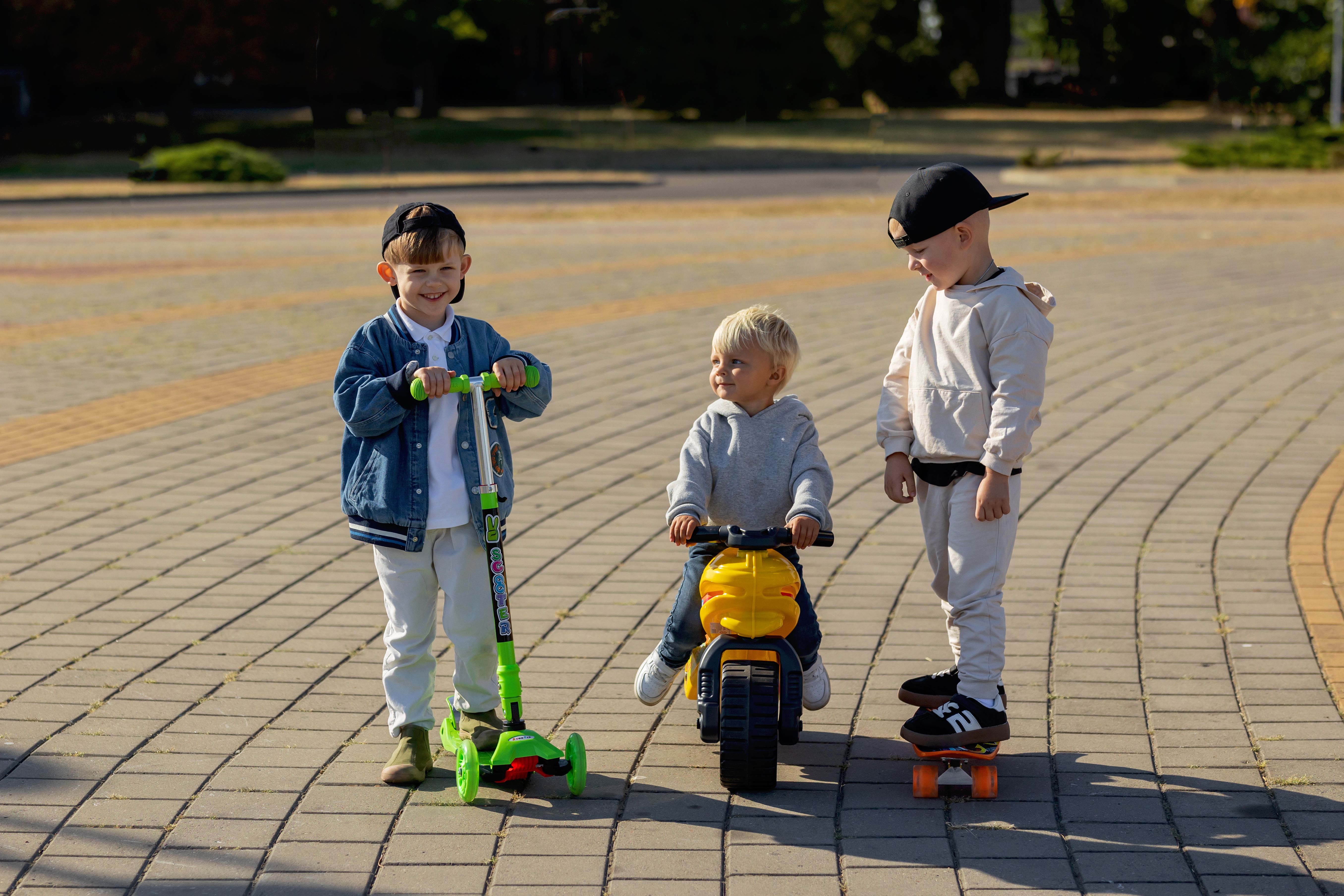 Playful Kids on Scooters and Trike Outside · Free Stock Photo