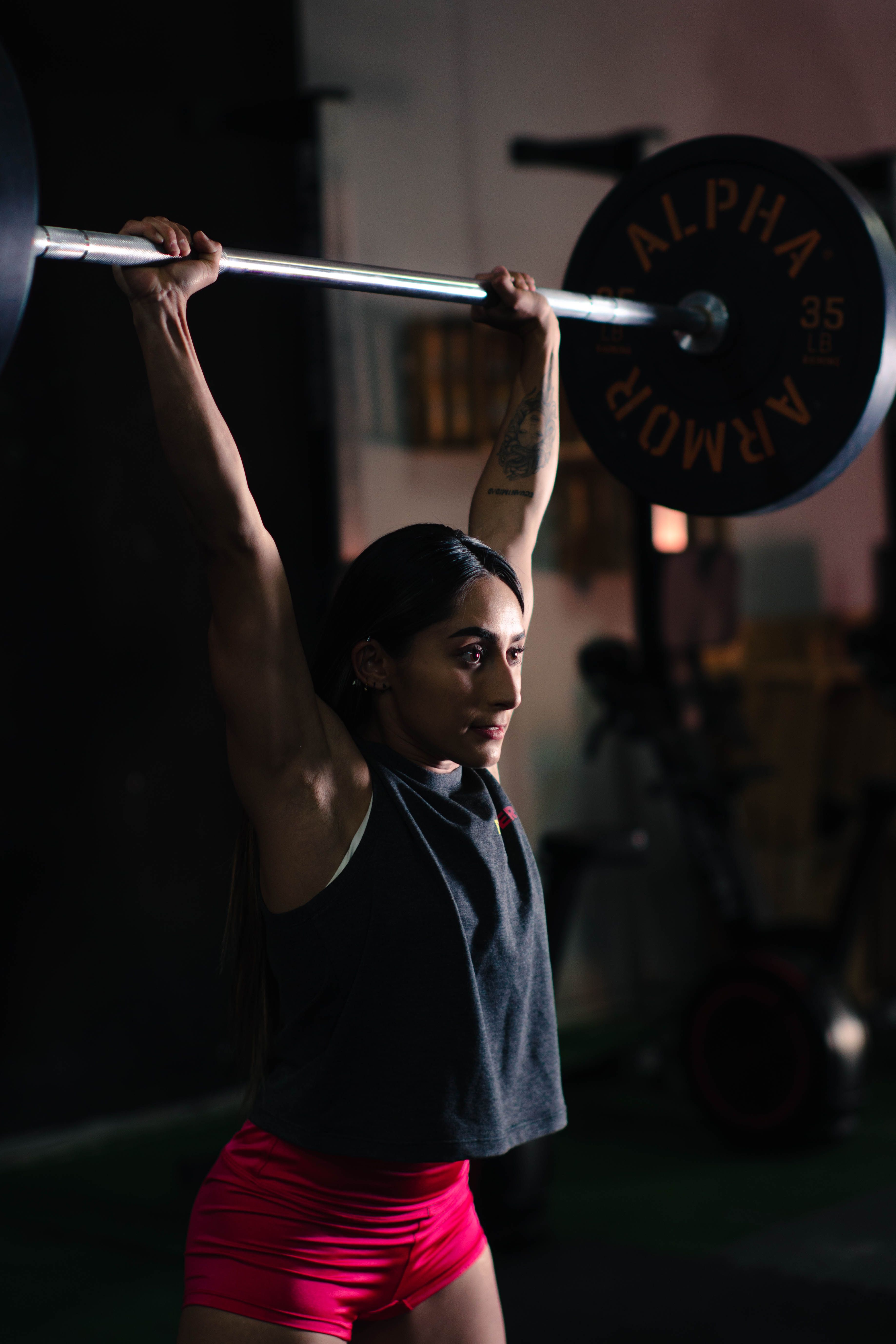 Woman Lifting Barbell in Gym Setting · Free Stock Photo