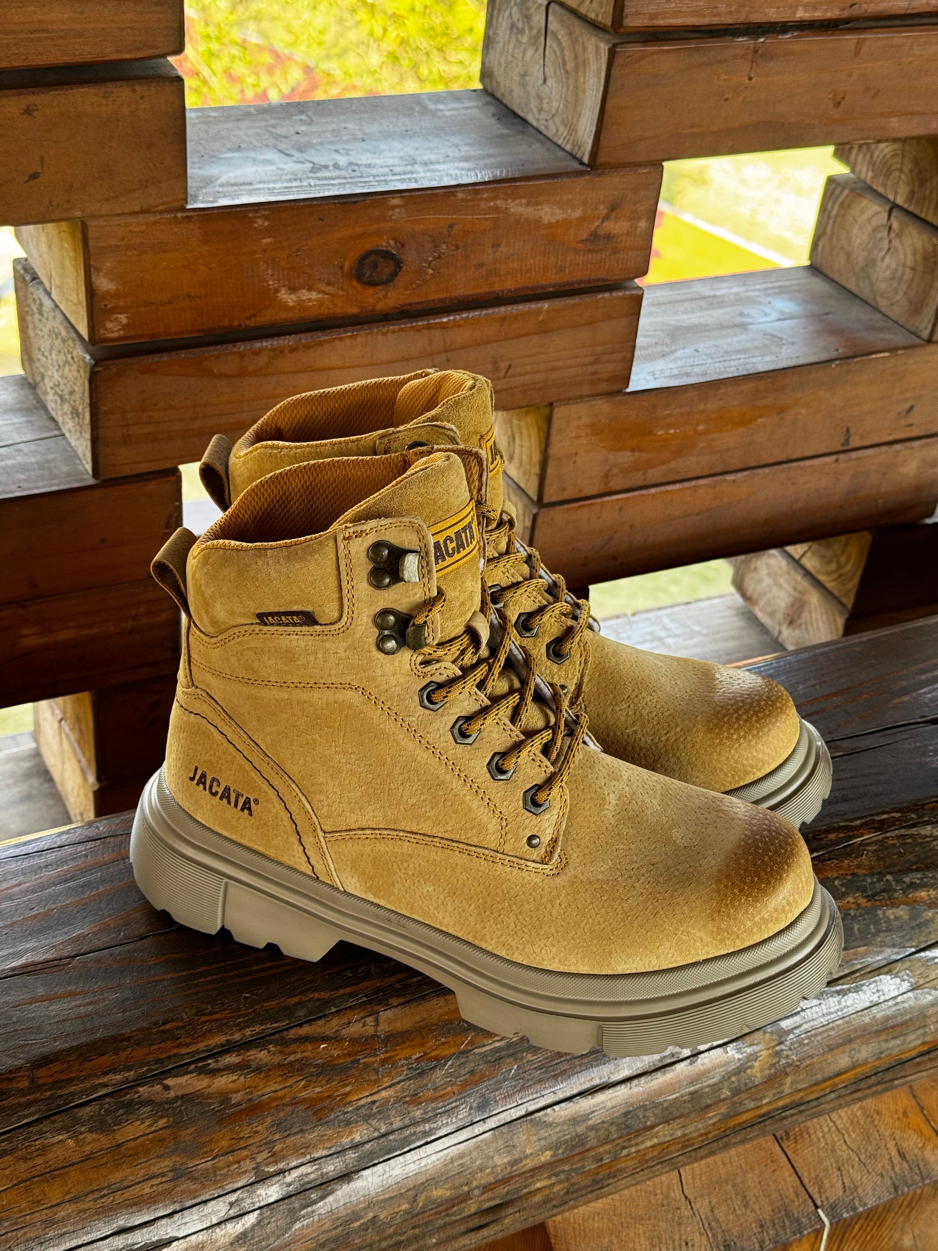 Pair of rugged outdoor hiking boots on wooden porch · Free Stock Photo