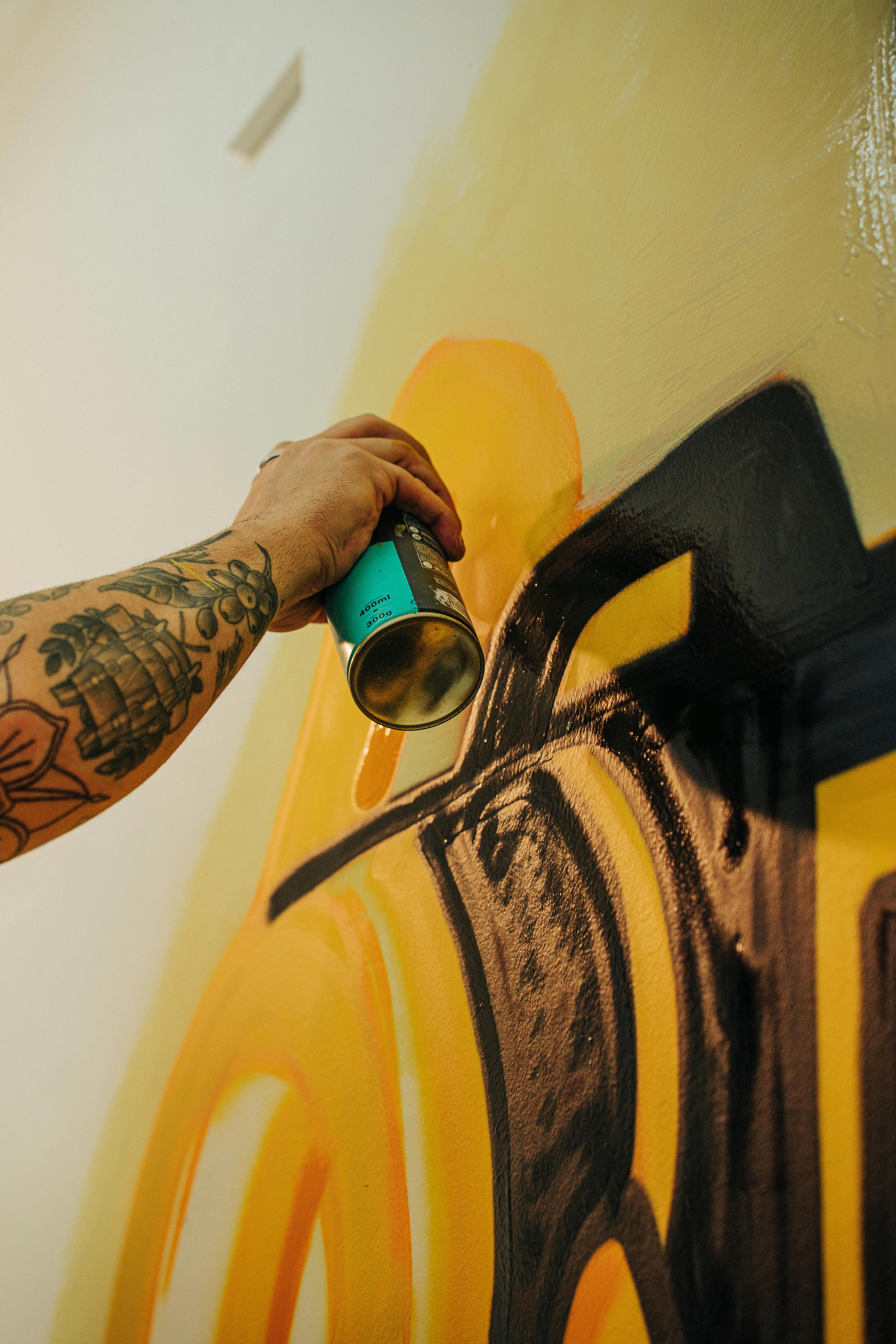 Tattooed Hand Spray Painting Vibrant Graffiti Art · Free Stock Photo