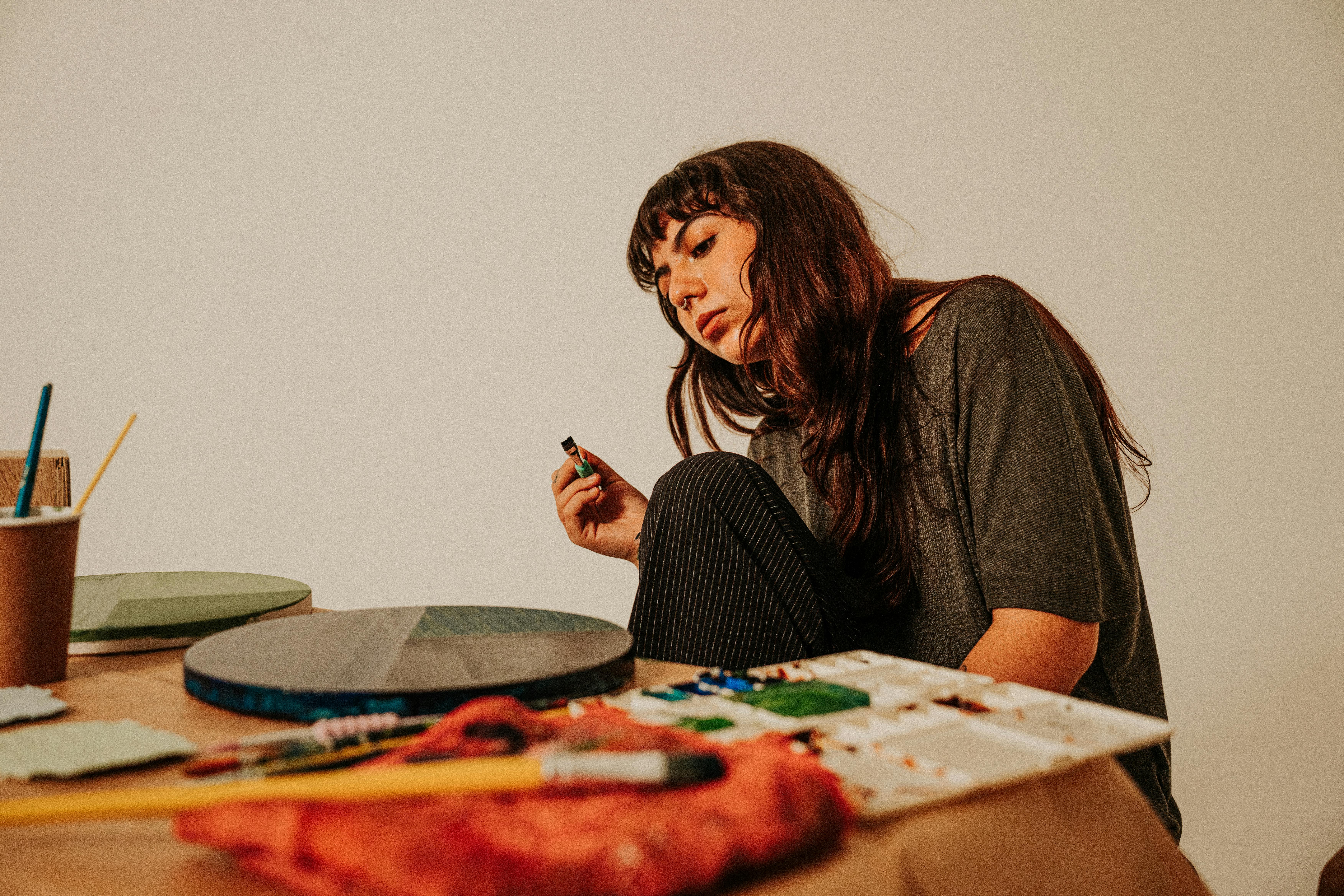 Contemplative Female Artist in Studio Setting · Free Stock Photo
