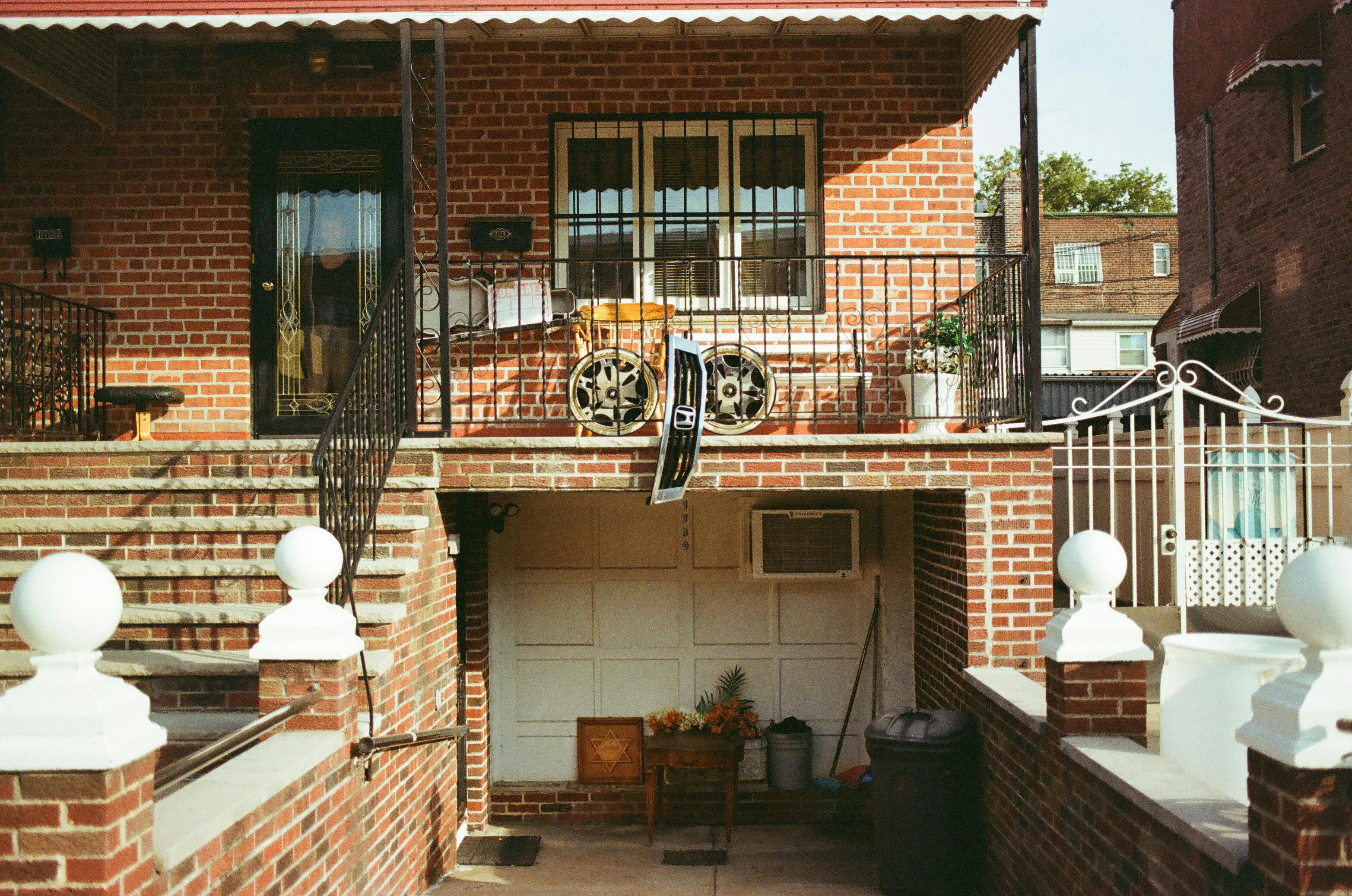 Charming Brick House Facade with Porch in Sunlight · Free Stock Photo