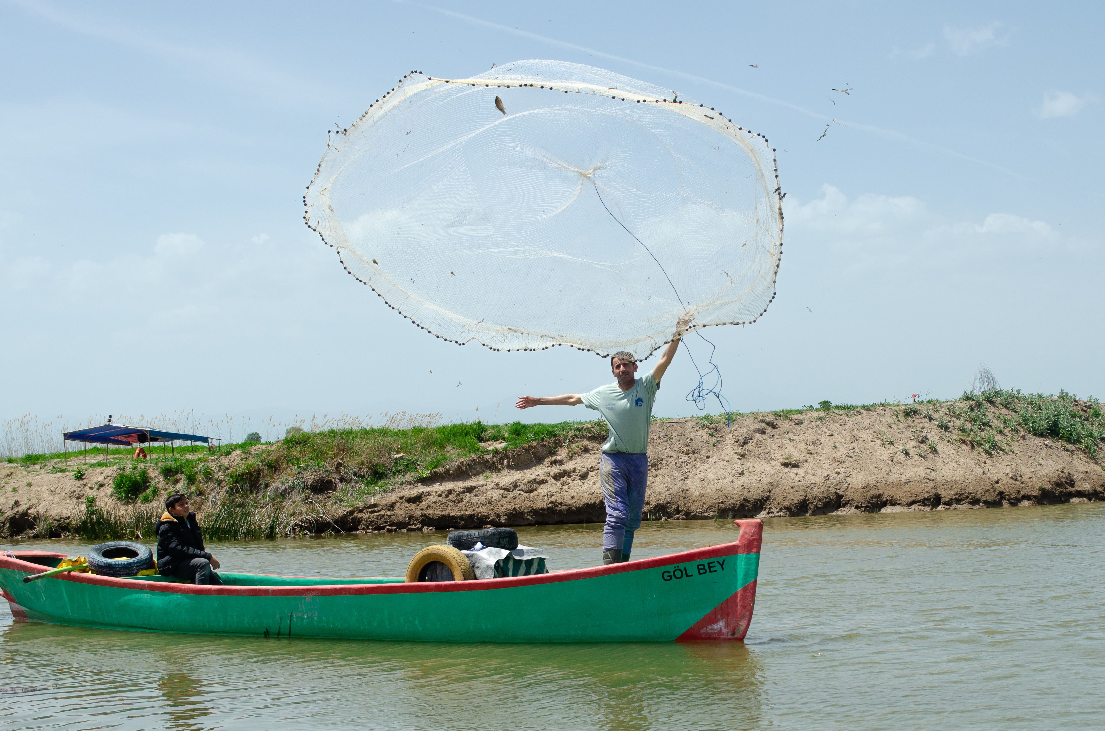 Fisherman Casting Net on a Bright Day in Türkiye · Free Stock Photo