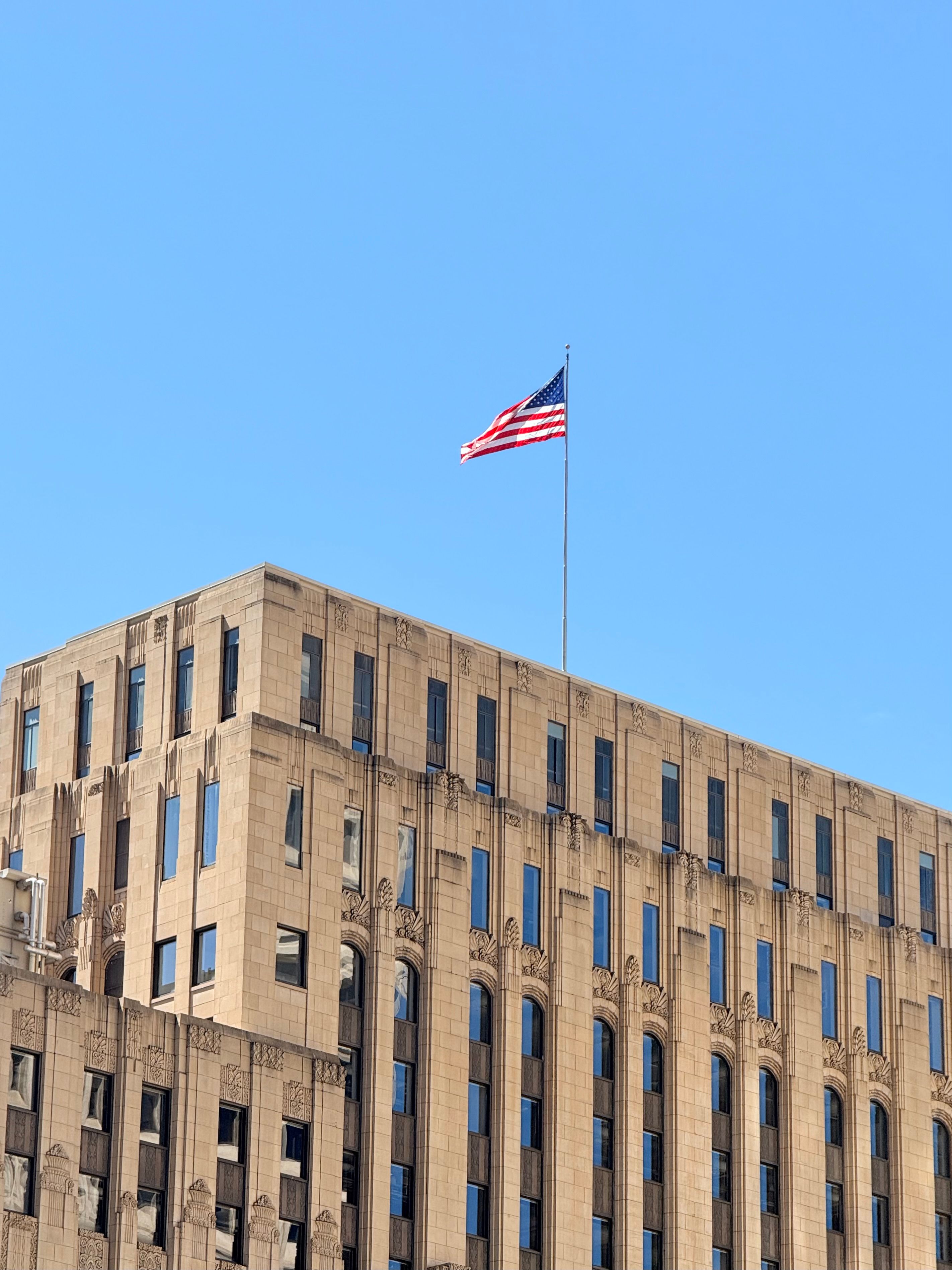American Flag on Historic Building Under Blue Sky · Free Stock Photo