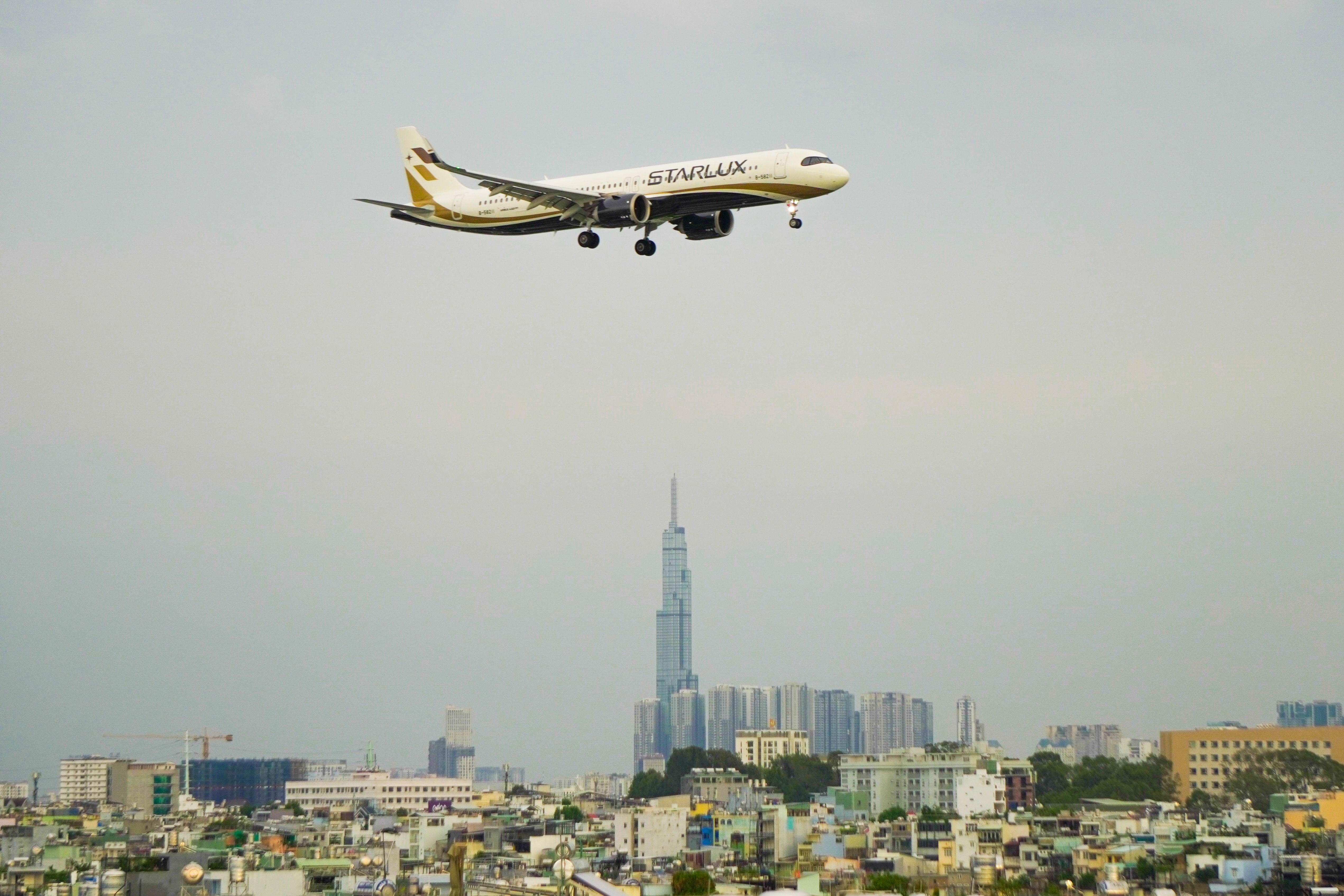 Airplane Flying Over Ho Chi Minh City Skyline · Free Stock Photo