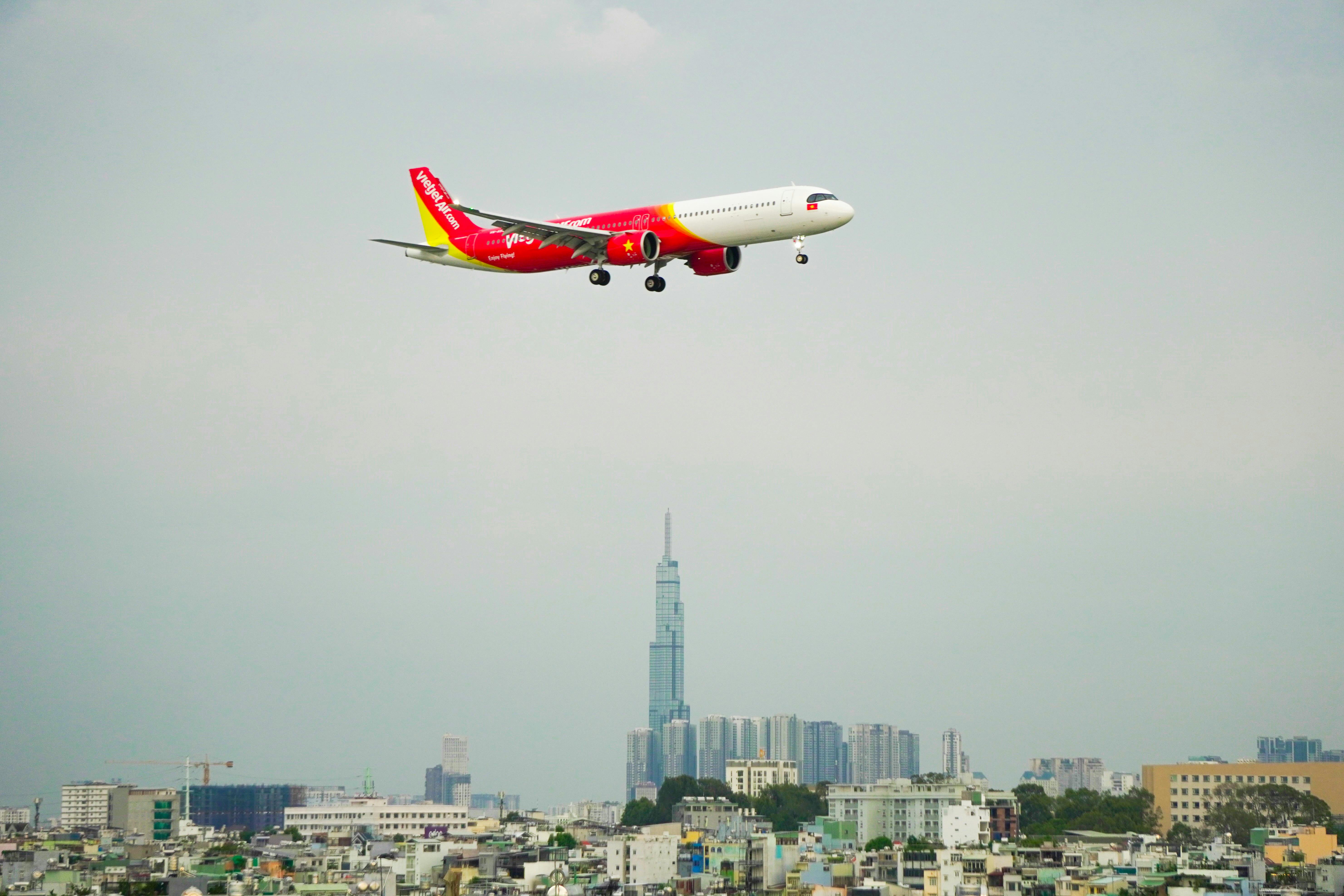 Airplane Flying Over City Skyline with Landmark · Free Stock Photo