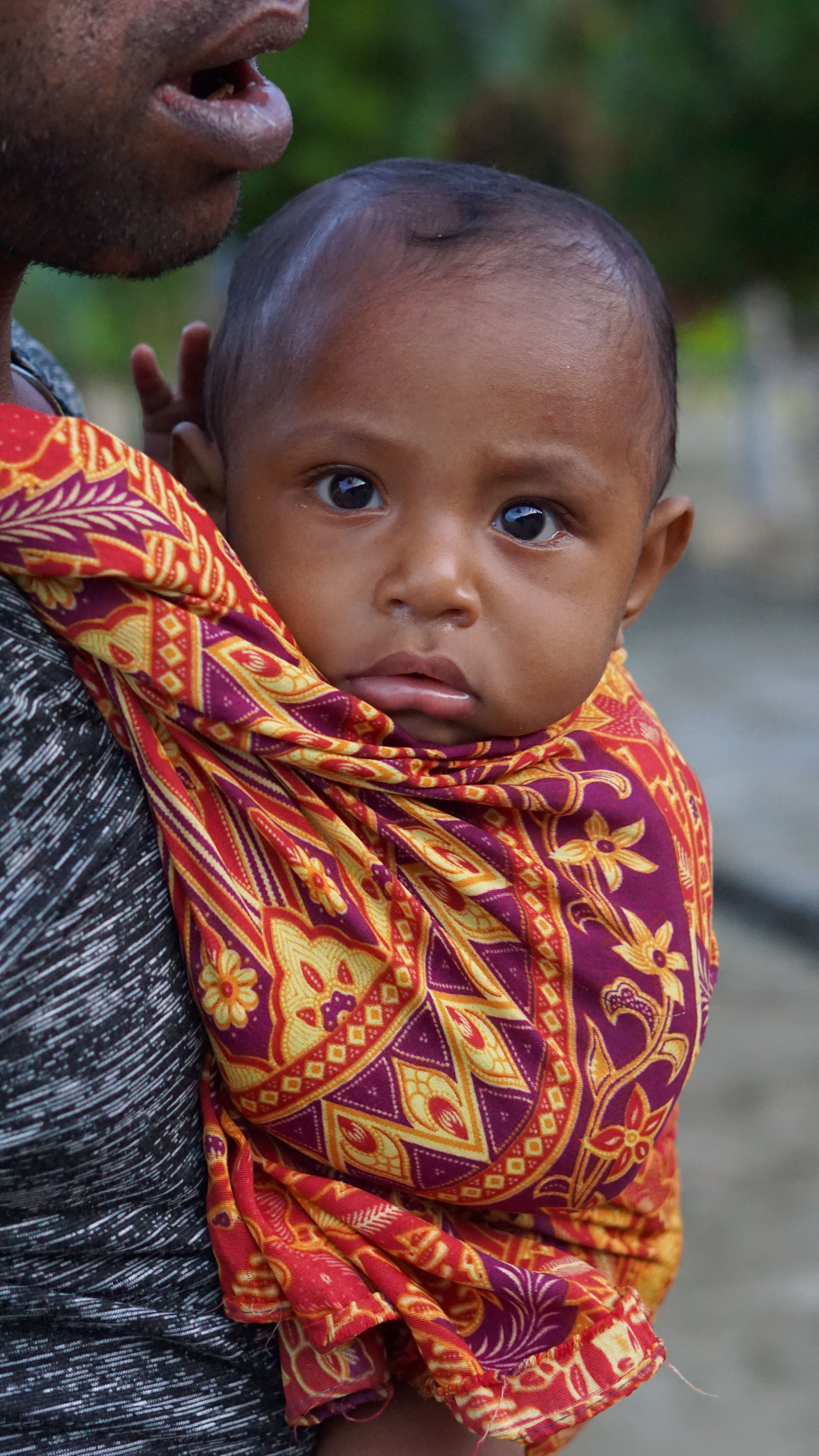 Papuan Baby in Vibrant Traditional Wrap · Free Stock Photo