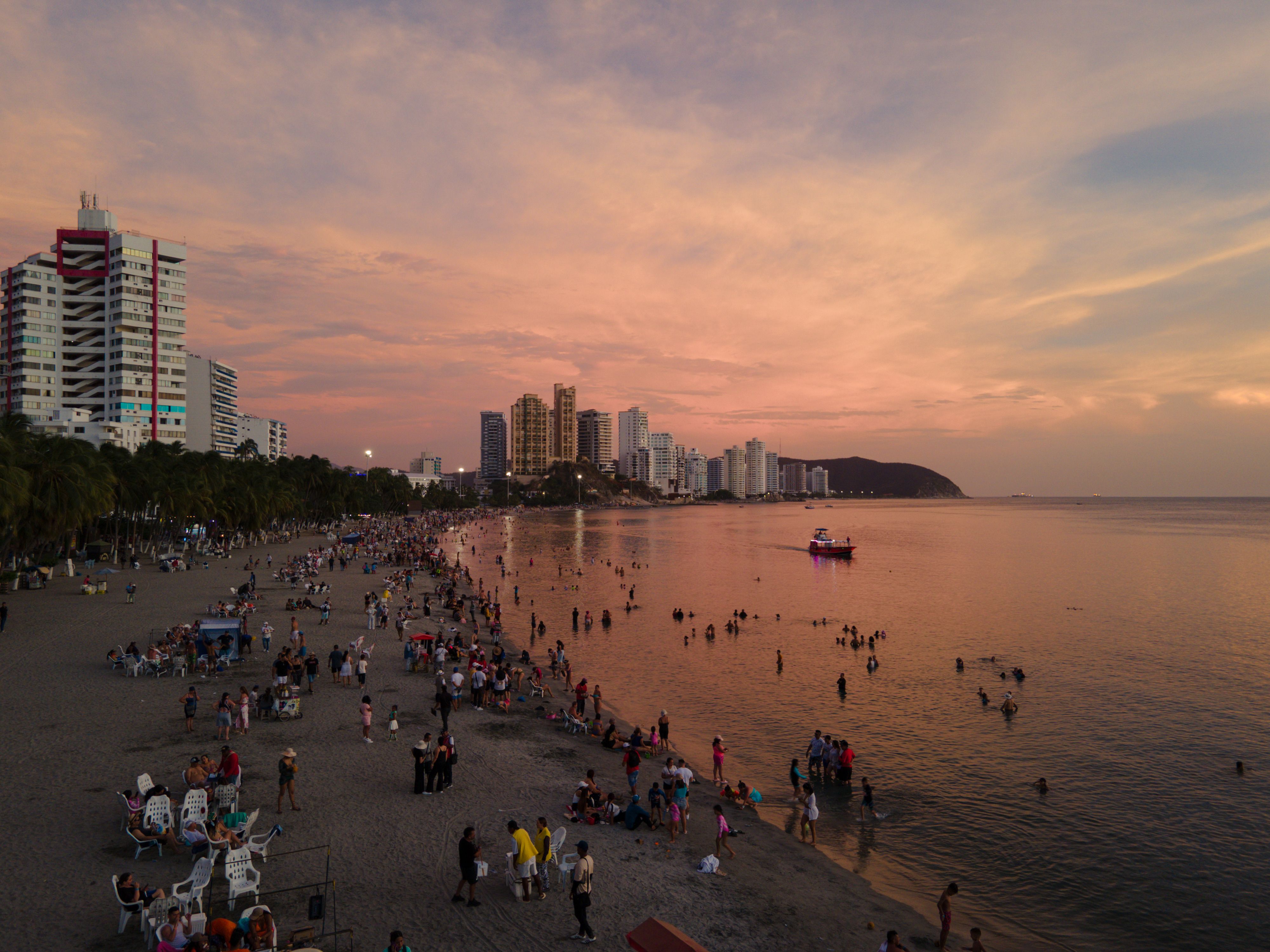 Beach Sunset Over City Skyline in Vibrant Colors · Free Stock Photo