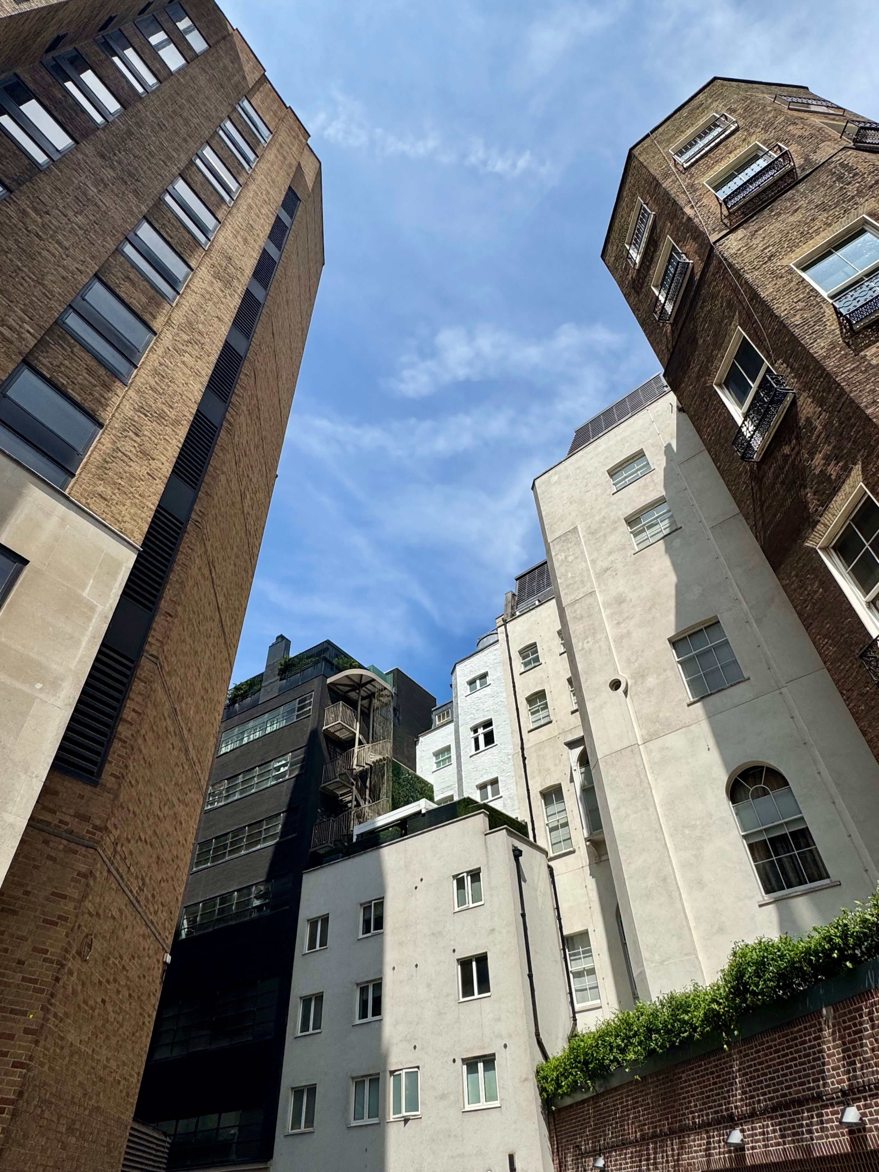 Urban Canyon with Tall Buildings under Blue Sky · Free Stock Photo